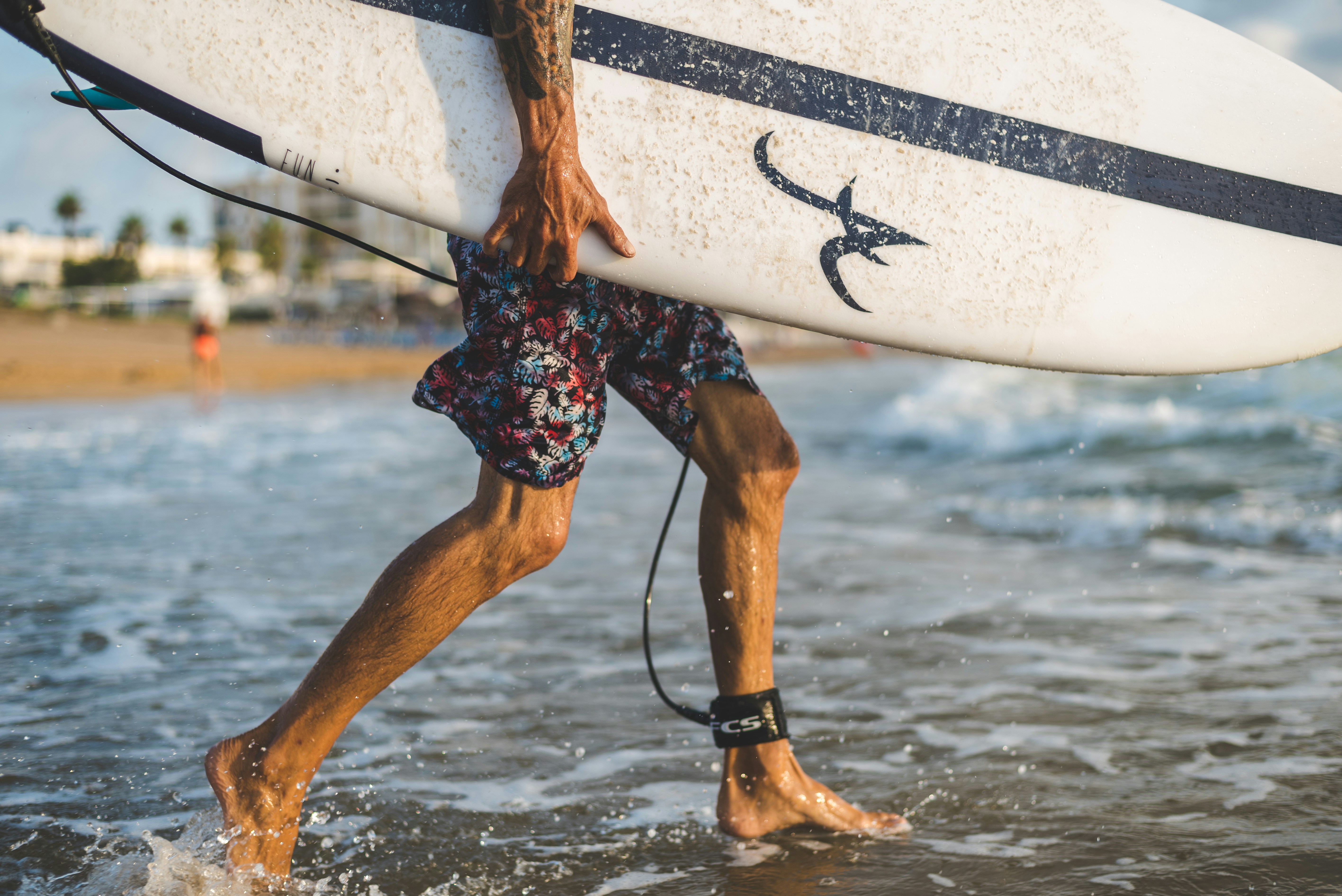 A man carrying a surfboard out of the ocean photo – Free Costa rica ...