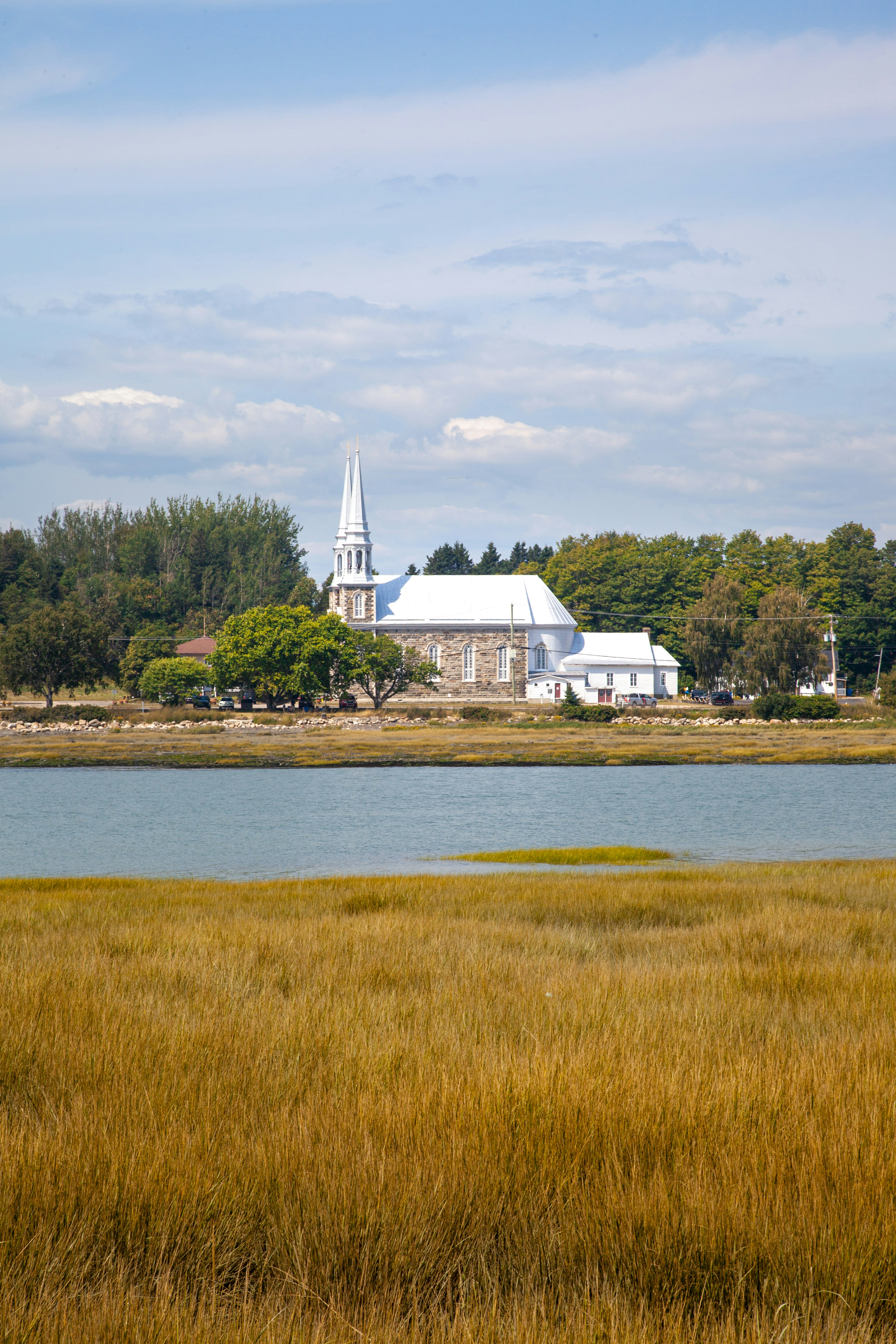 a large white church sitting on top of a lush green field