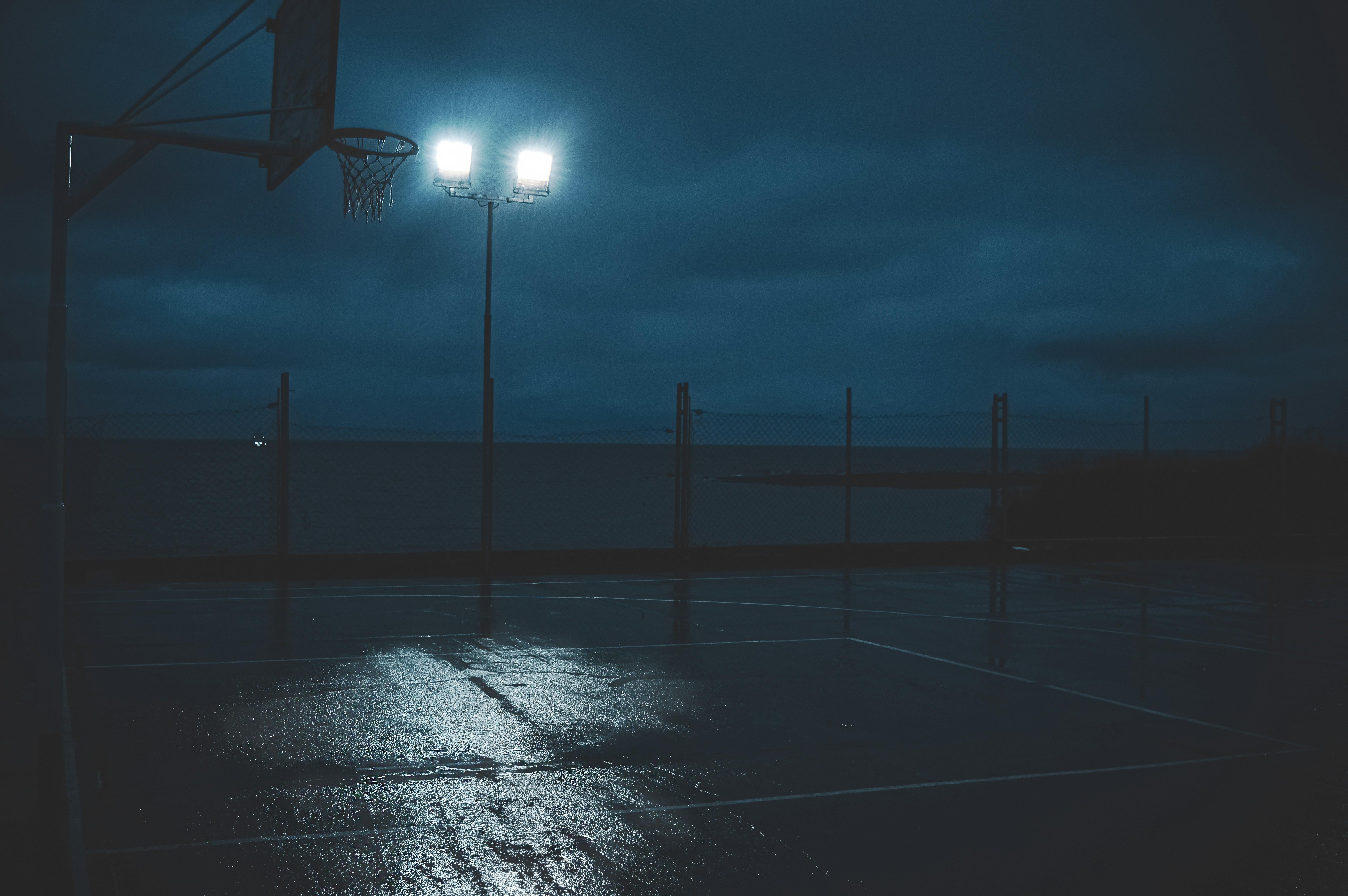 A basketball court at night with a basketball hoop photo – Free Grey ...