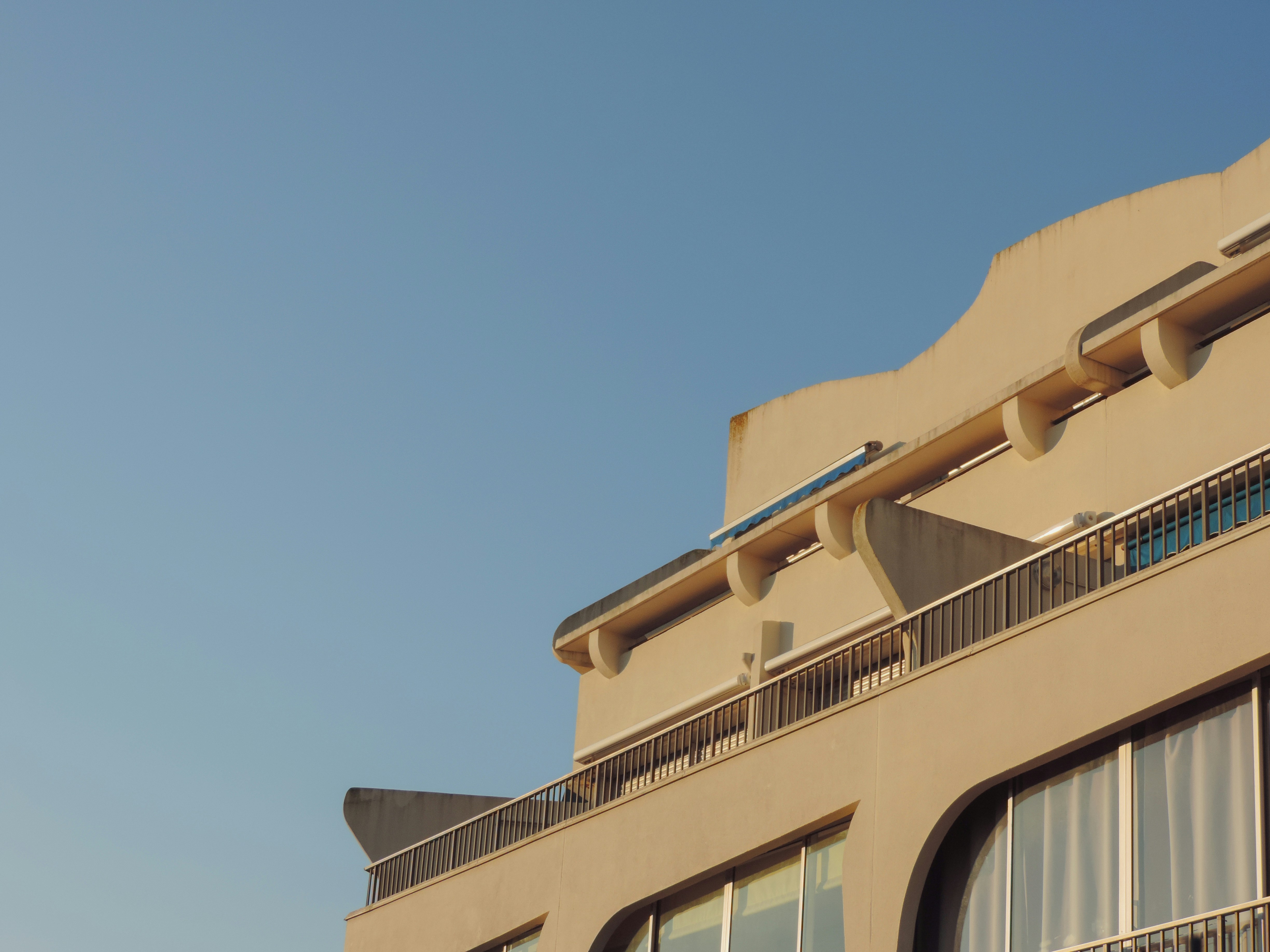A tan building with balconies and a blue sky photo – Free Port camargue ...
