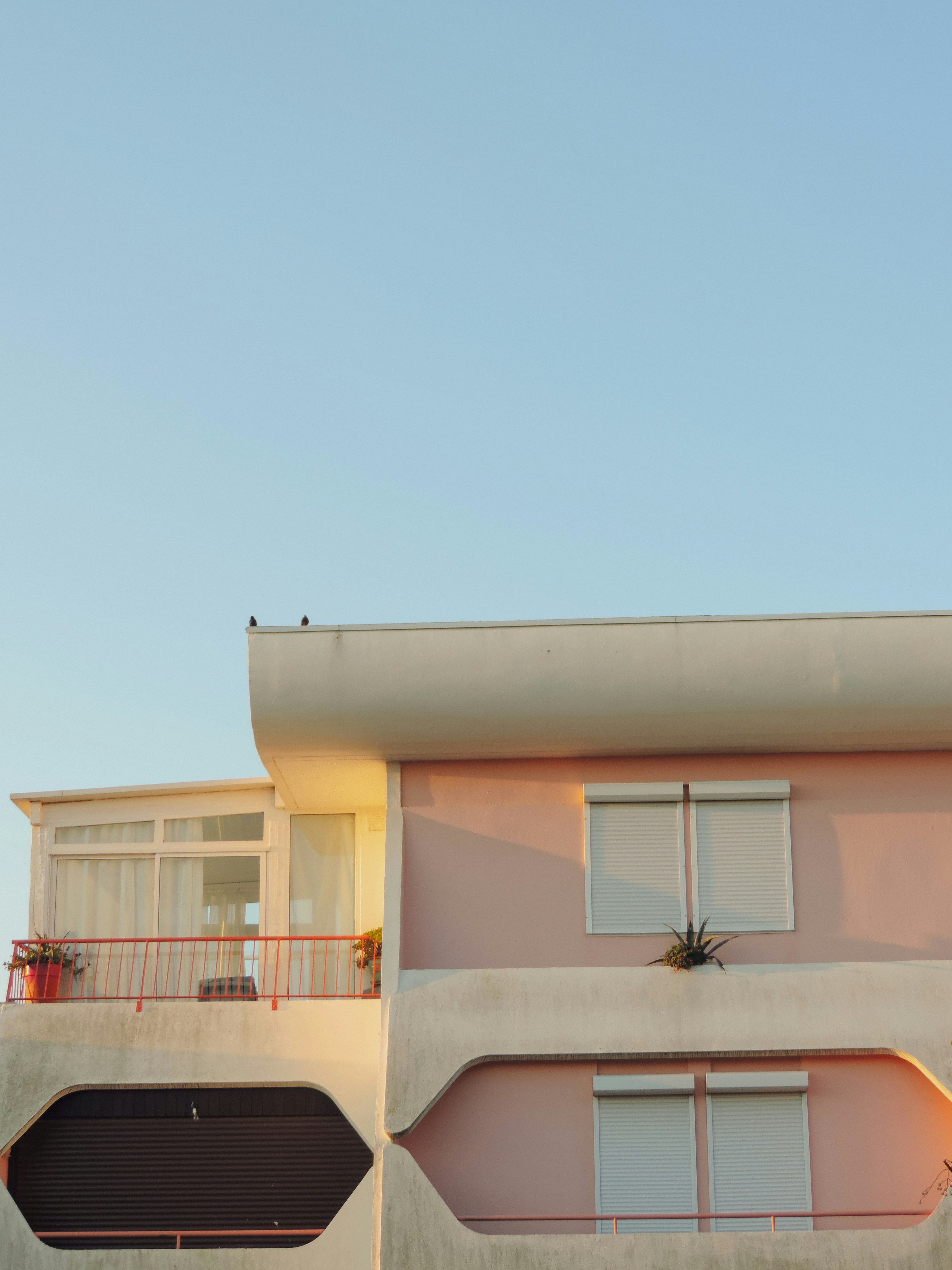 Contemporary building facade featuring clean lines, pastel colors, and geometric shapes. The design emphasizes simplicity and elegance.