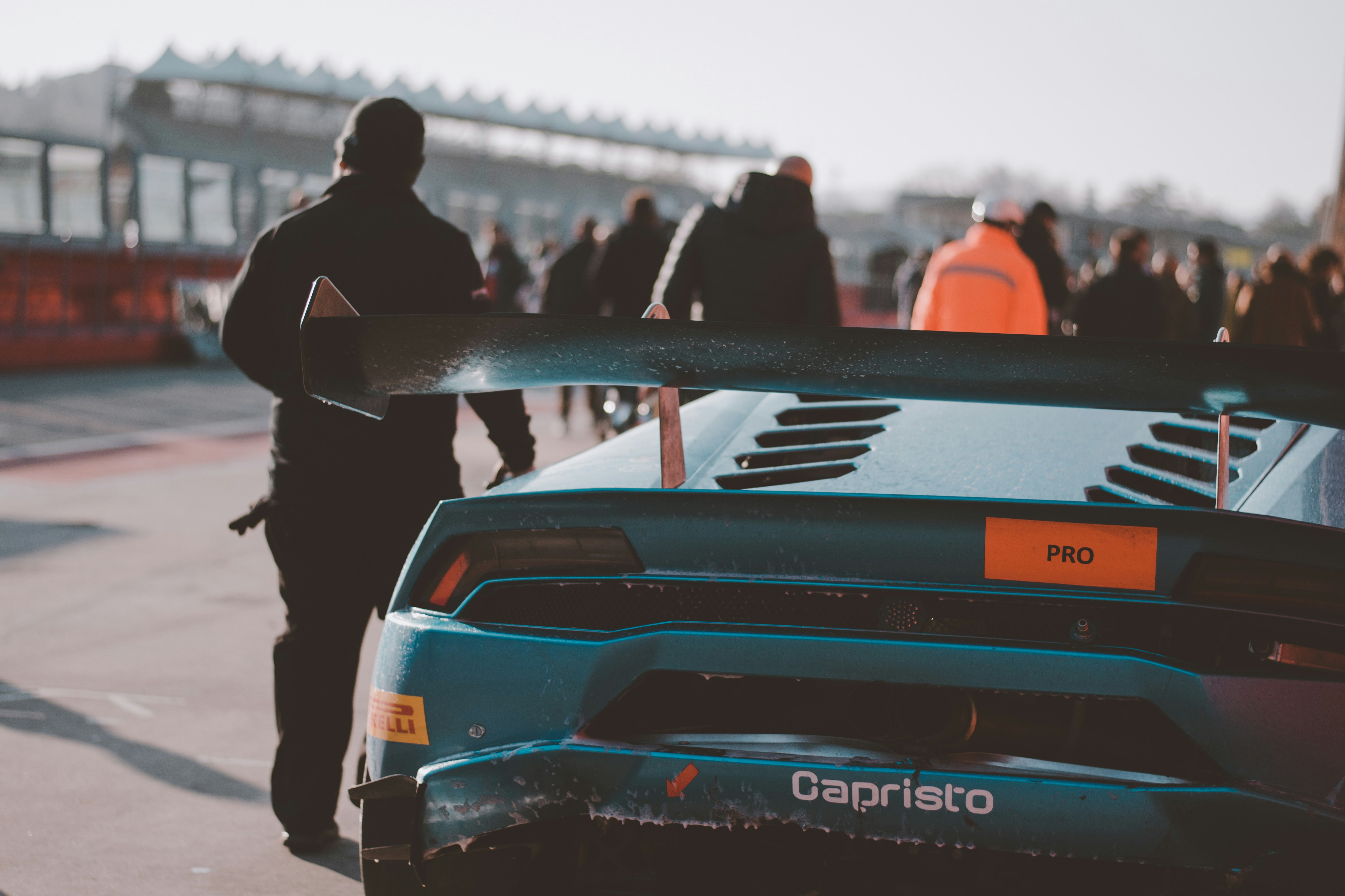 Foto Un hombre parado junto a un auto deportivo azul – Imagen Corredor ...