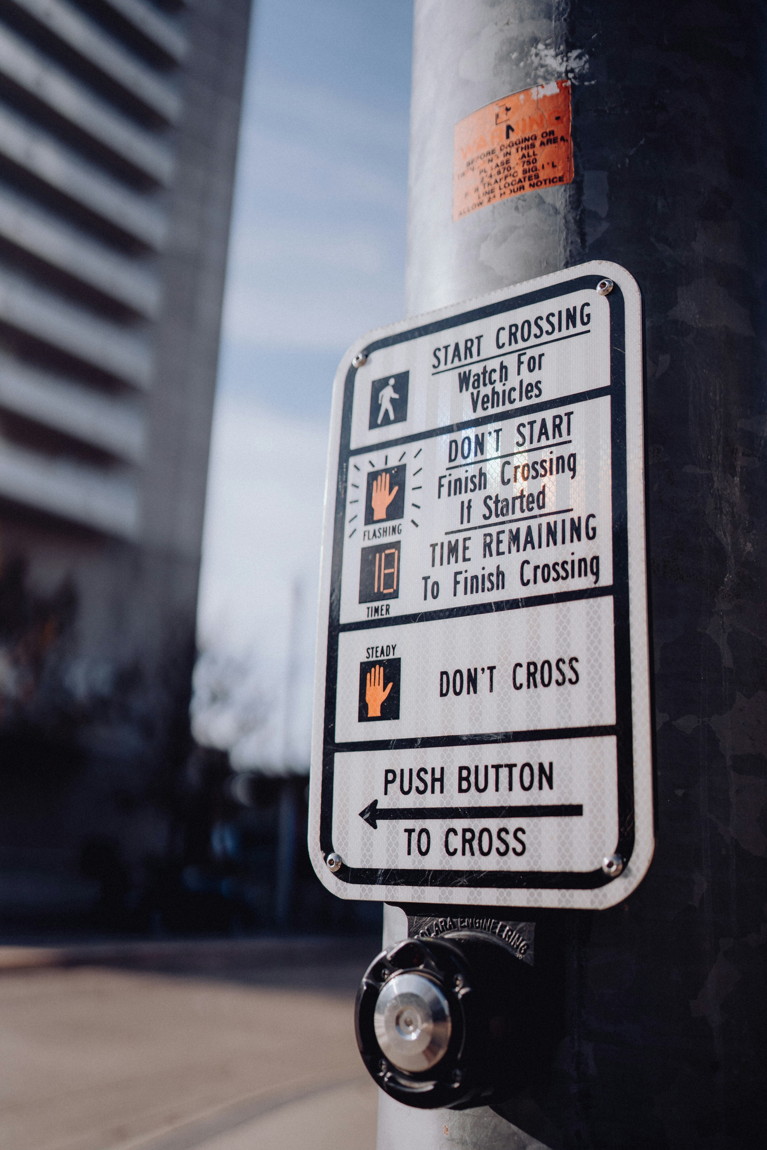 Traffic signal display providing instructions for pedestrians at a crosswalk, emphasizing safety measures and timing.