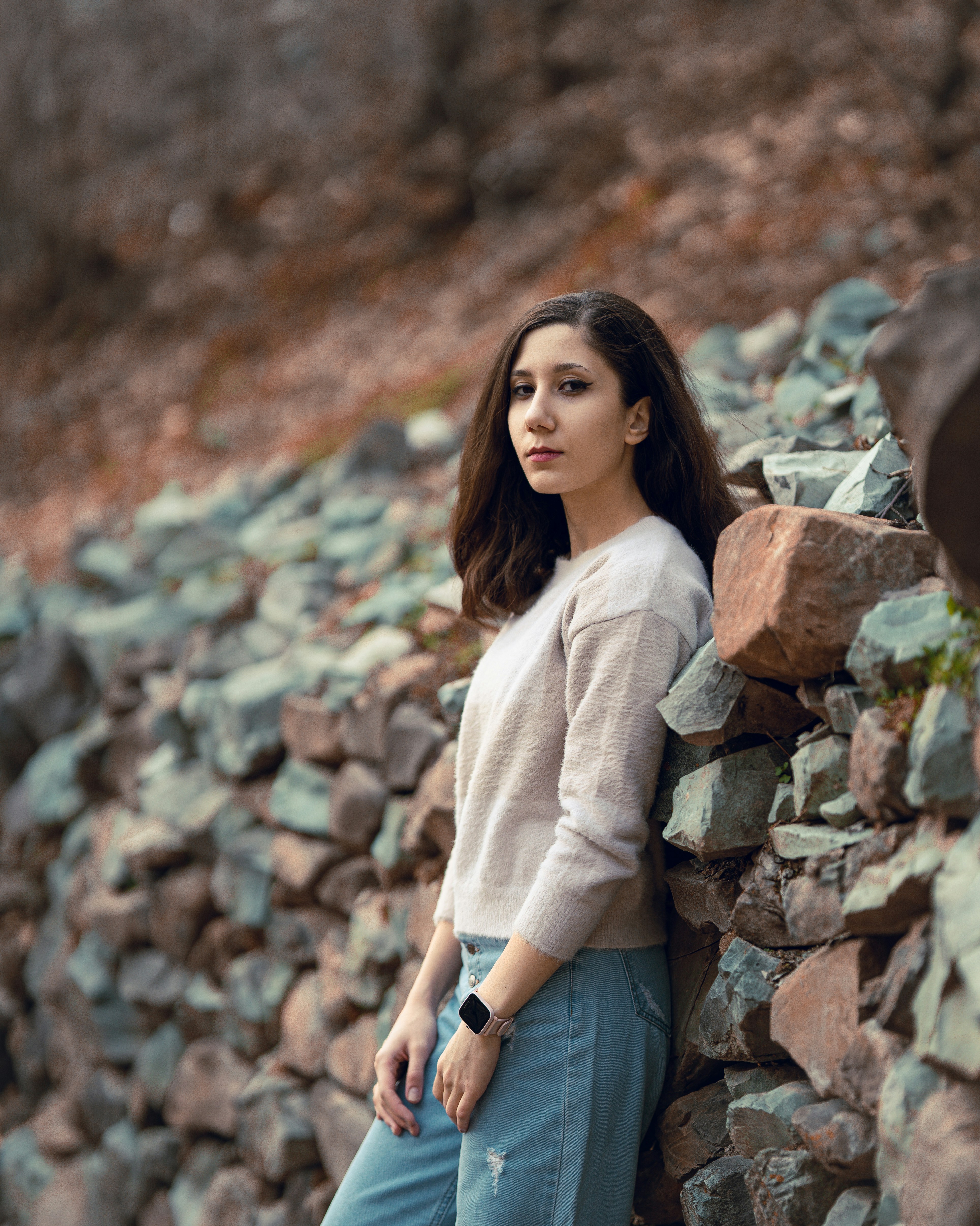 A woman leaning against a rock wall photo – Free Afjeh Image on Unsplash