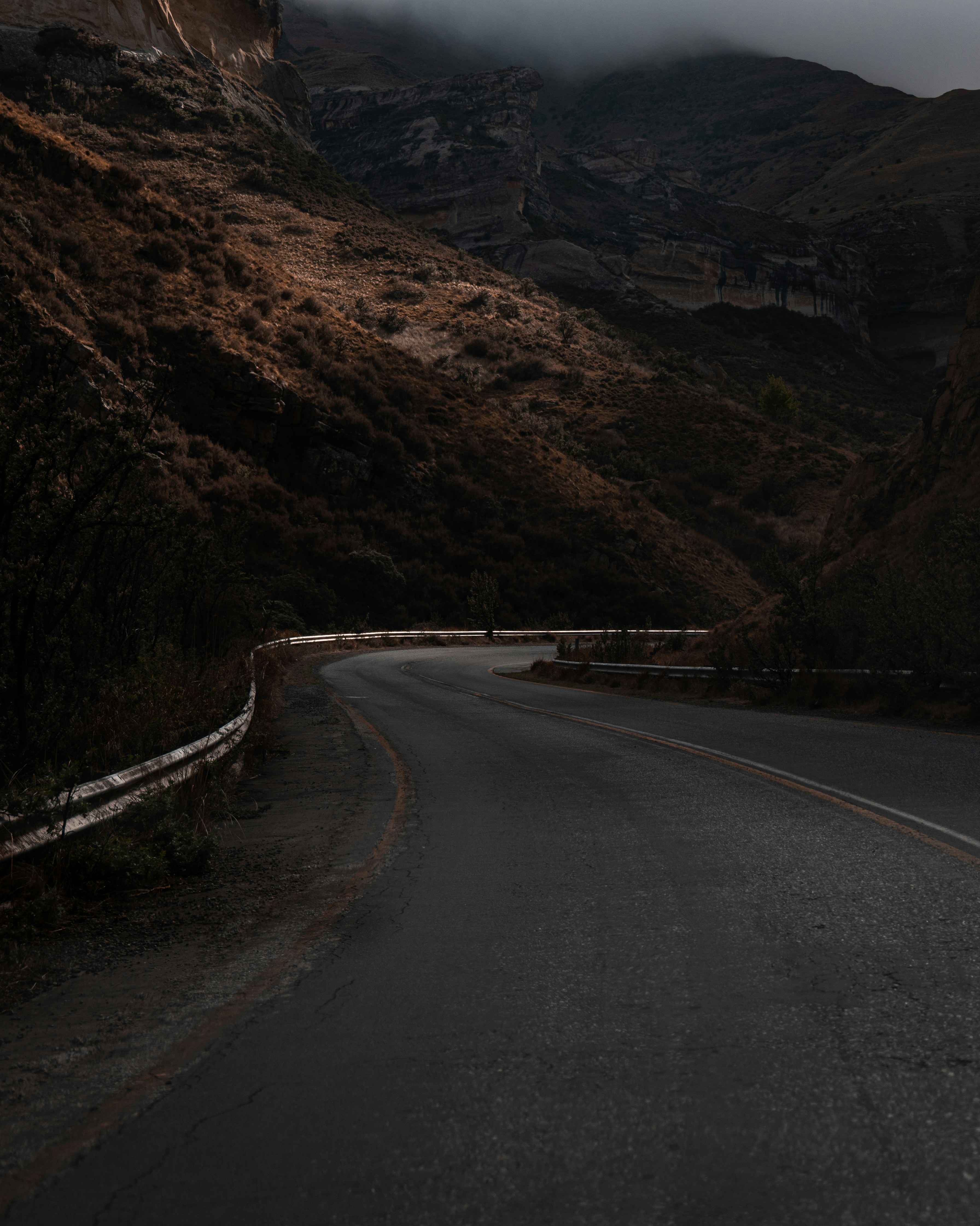 a dark road with a mountain in the background