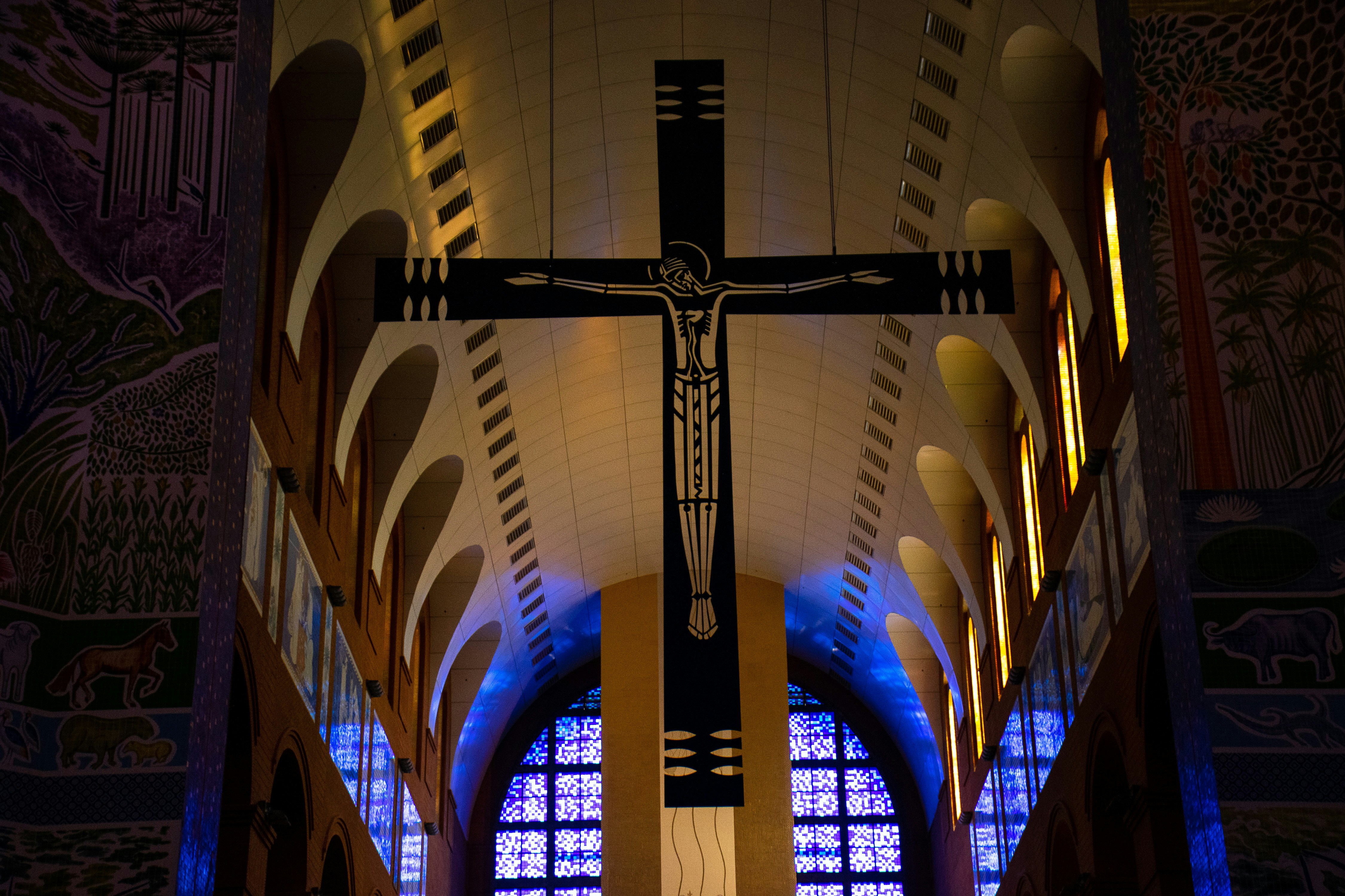A large cross hanging from the ceiling of a church photo – Free ...