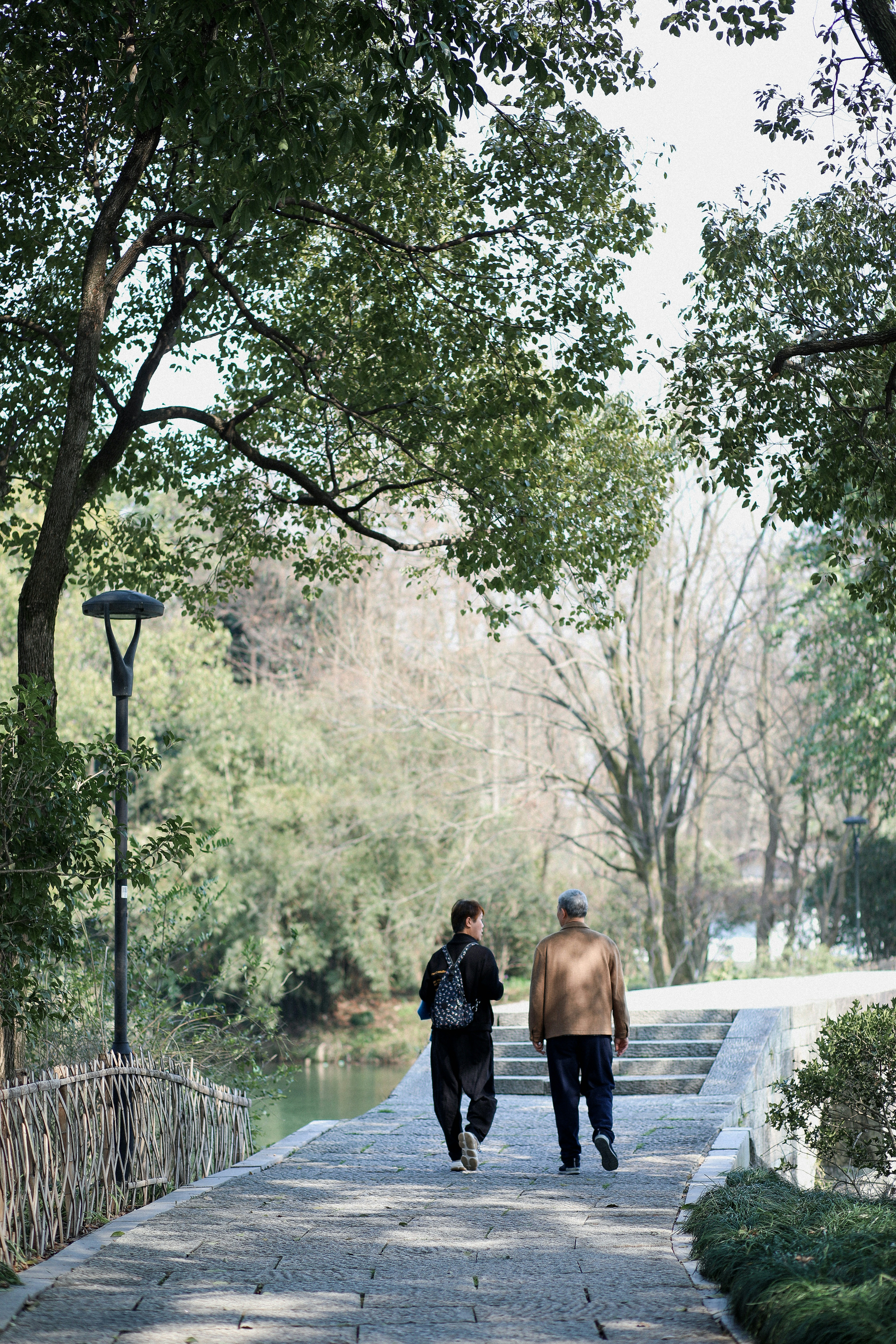 Un couple de personnes marchant sur un trottoir photo – Photo Gris ...