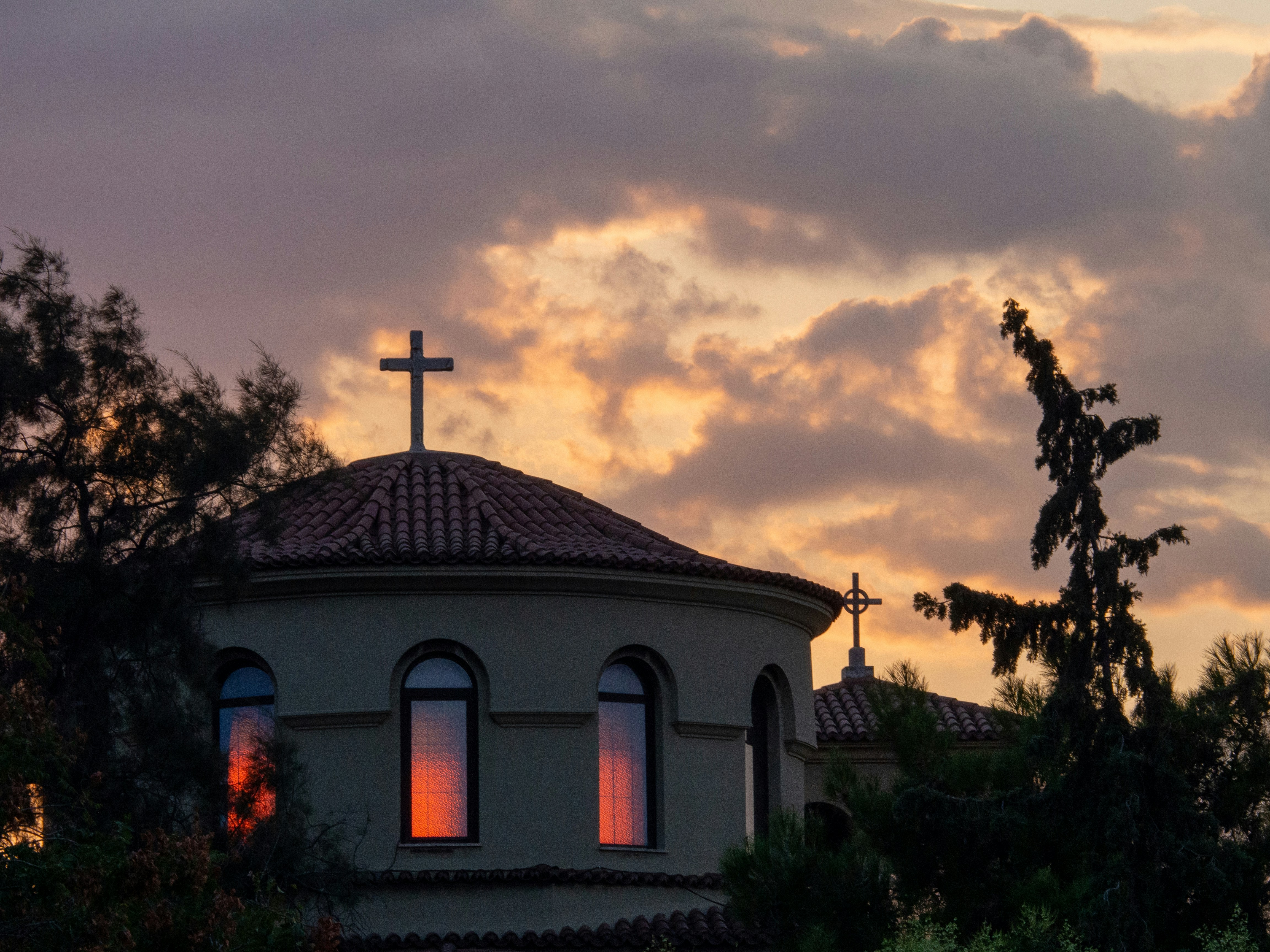Dusk Glow Through the Arched Windows of a Cross-Topped Chapel