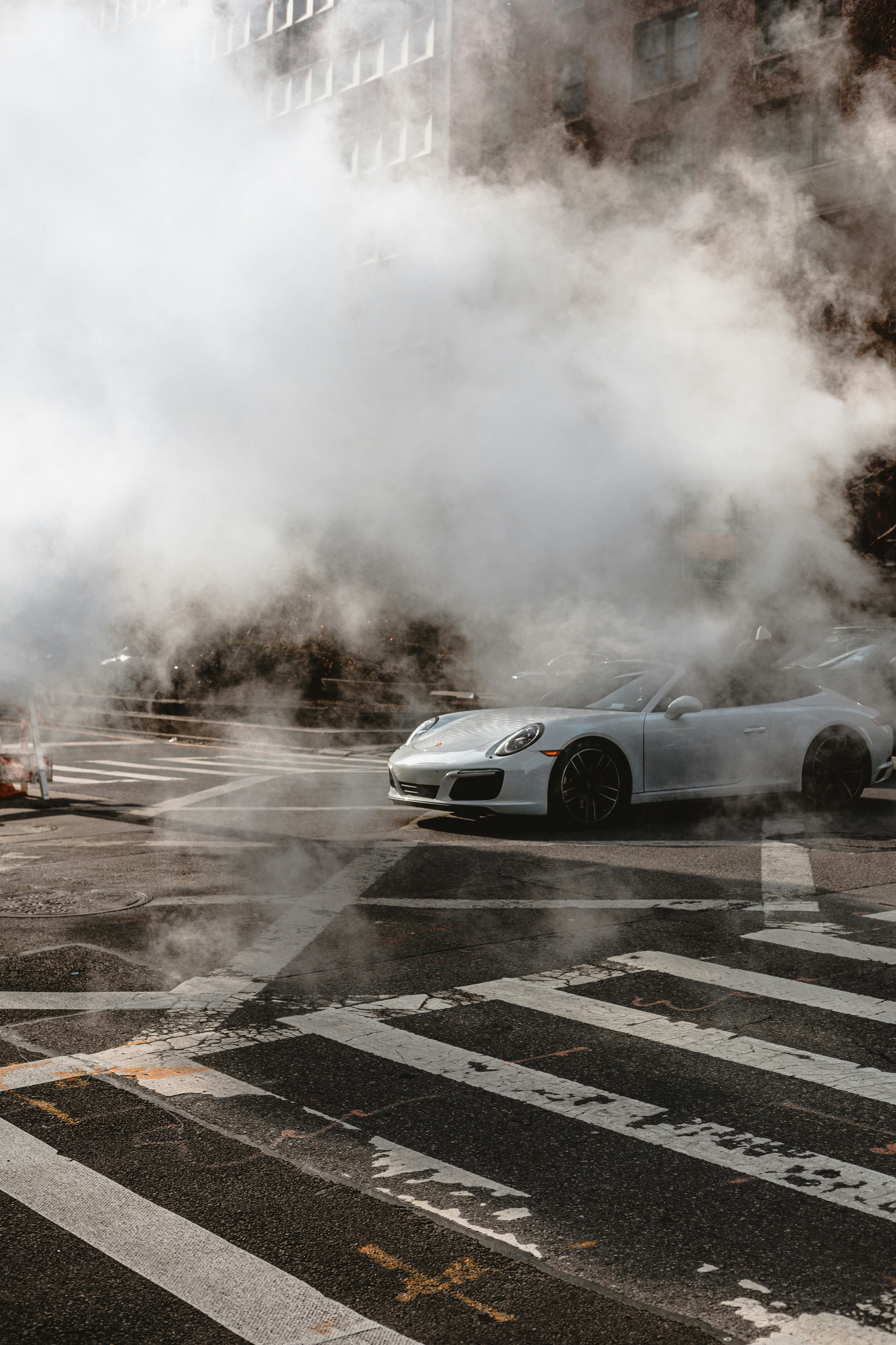 White Porsche Through a Smoke Curtain at an Urban Crosswalk