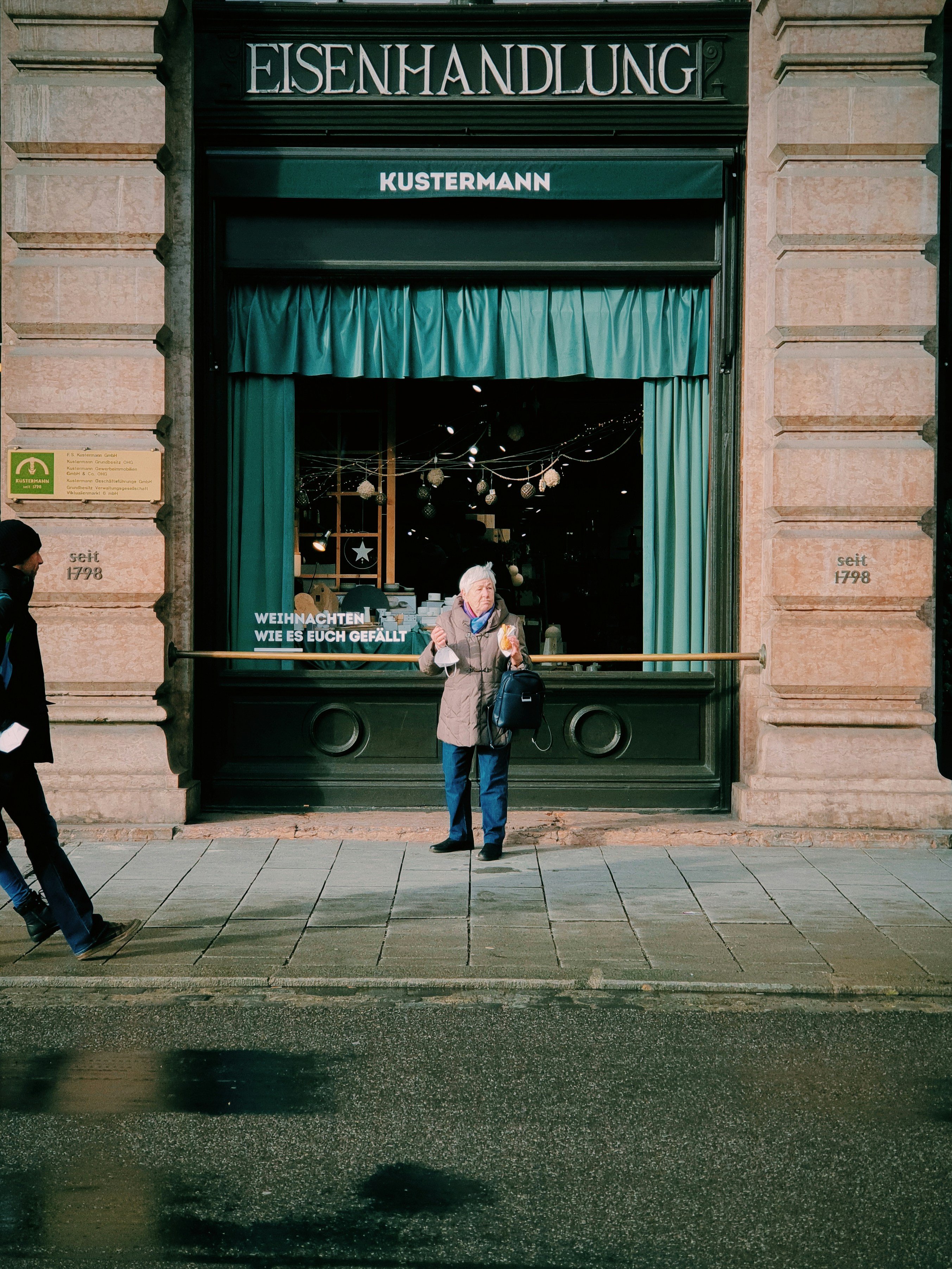 Two people walking down a sidewalk in front of a store photo – Free ...