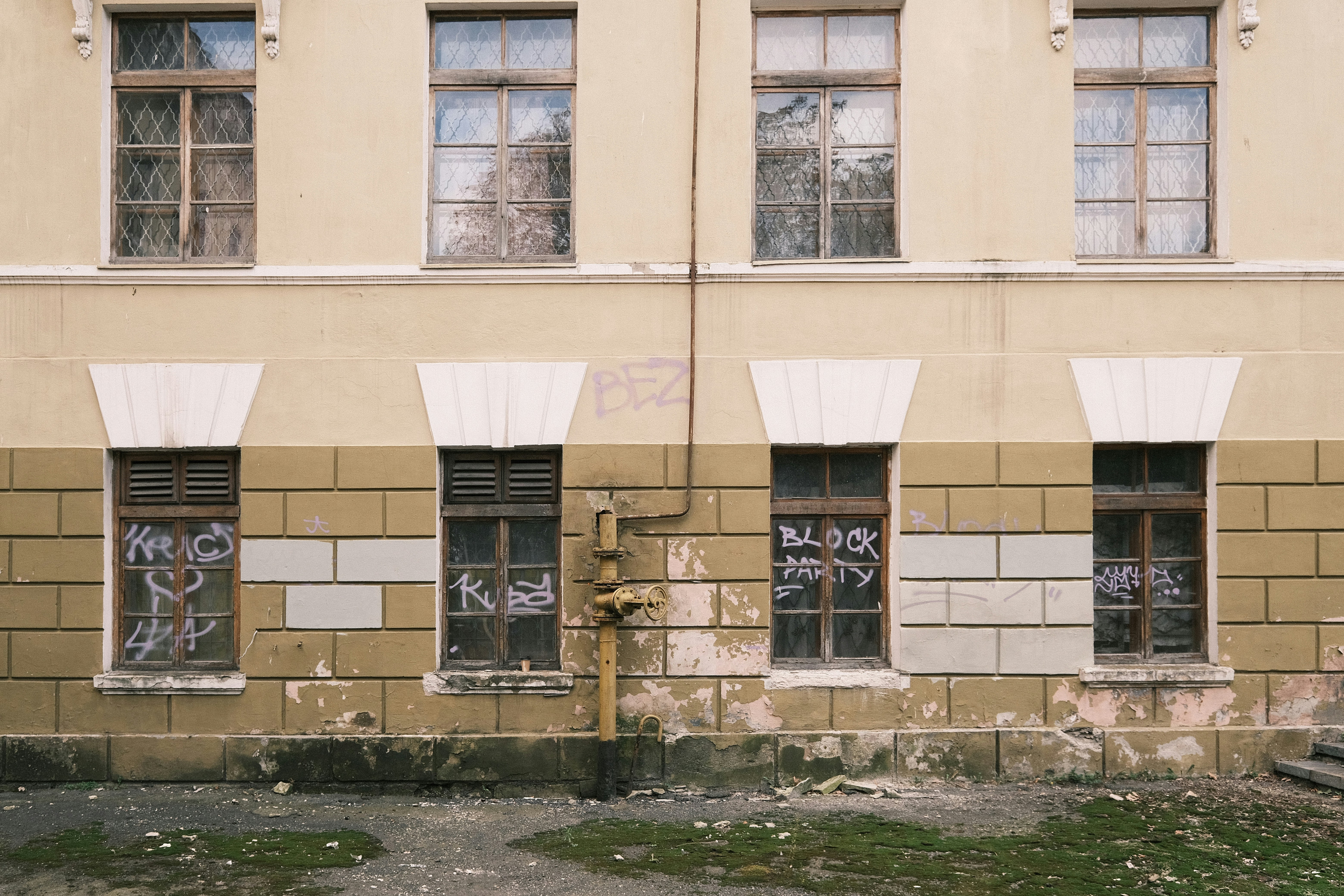 Weathered building facade adorned with graffiti, revealing layers of history and neglect.