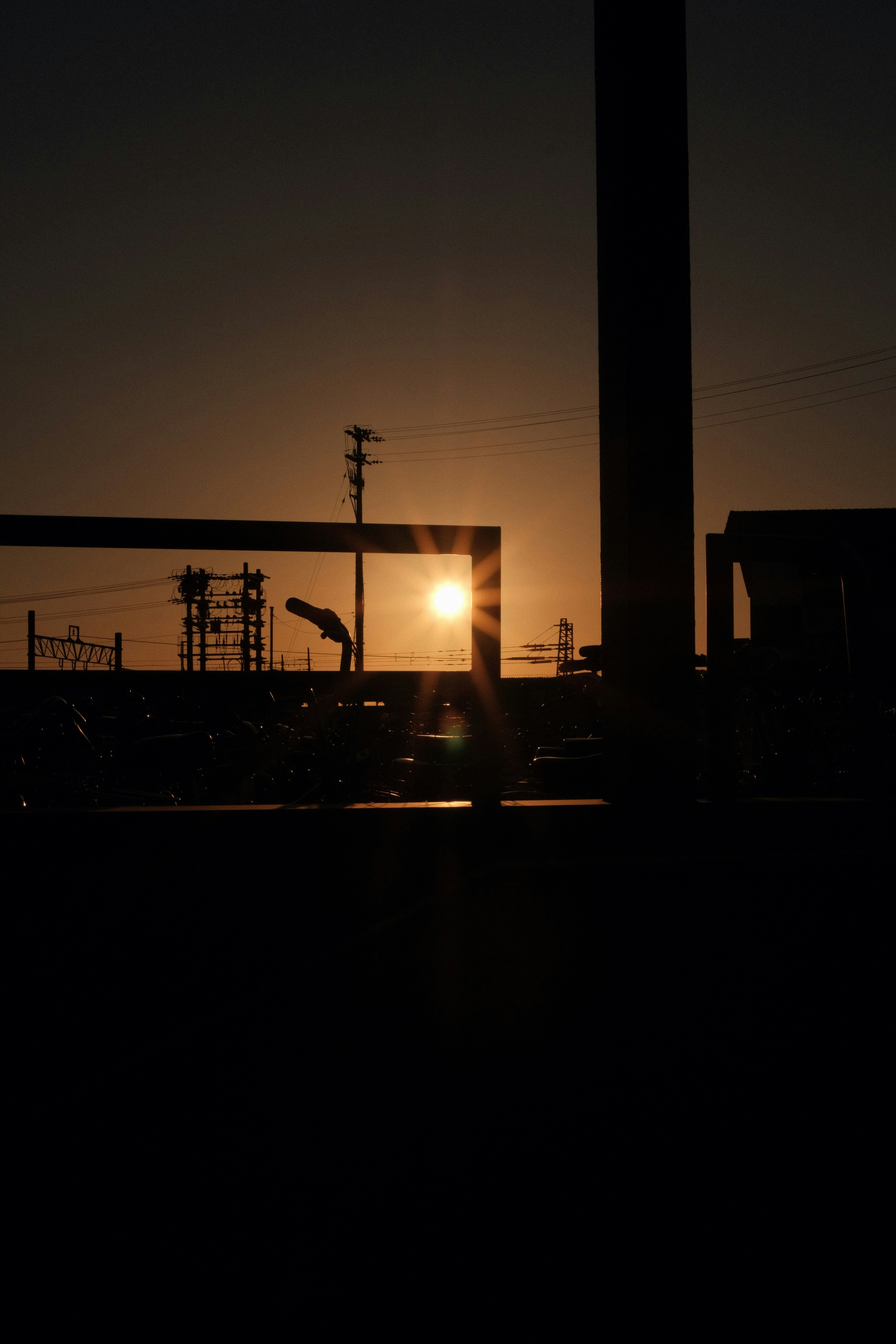 the sun is setting behind a power plant