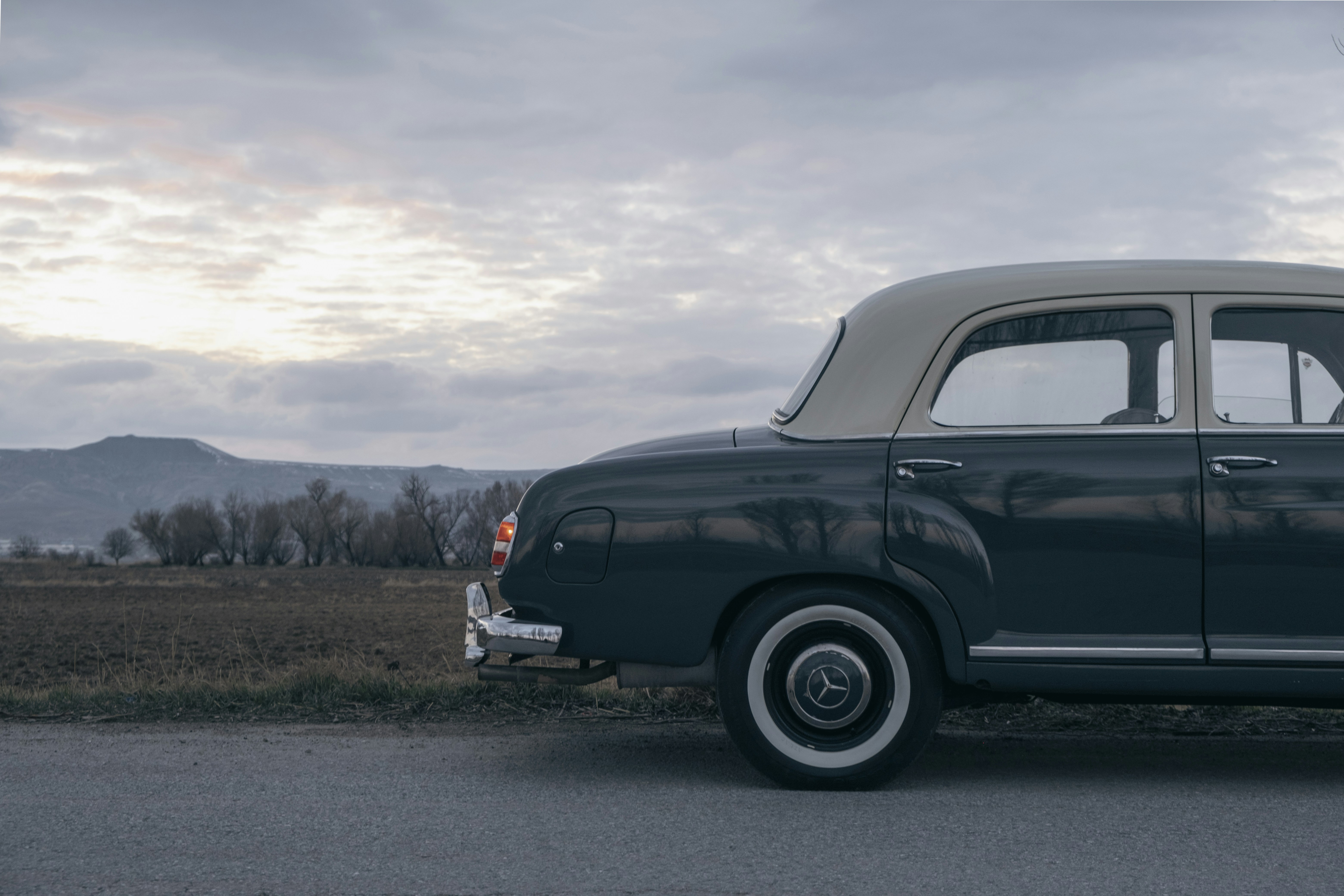 Tailfin at Dusk: A 1950s Sedan on a Quiet Prairie Road