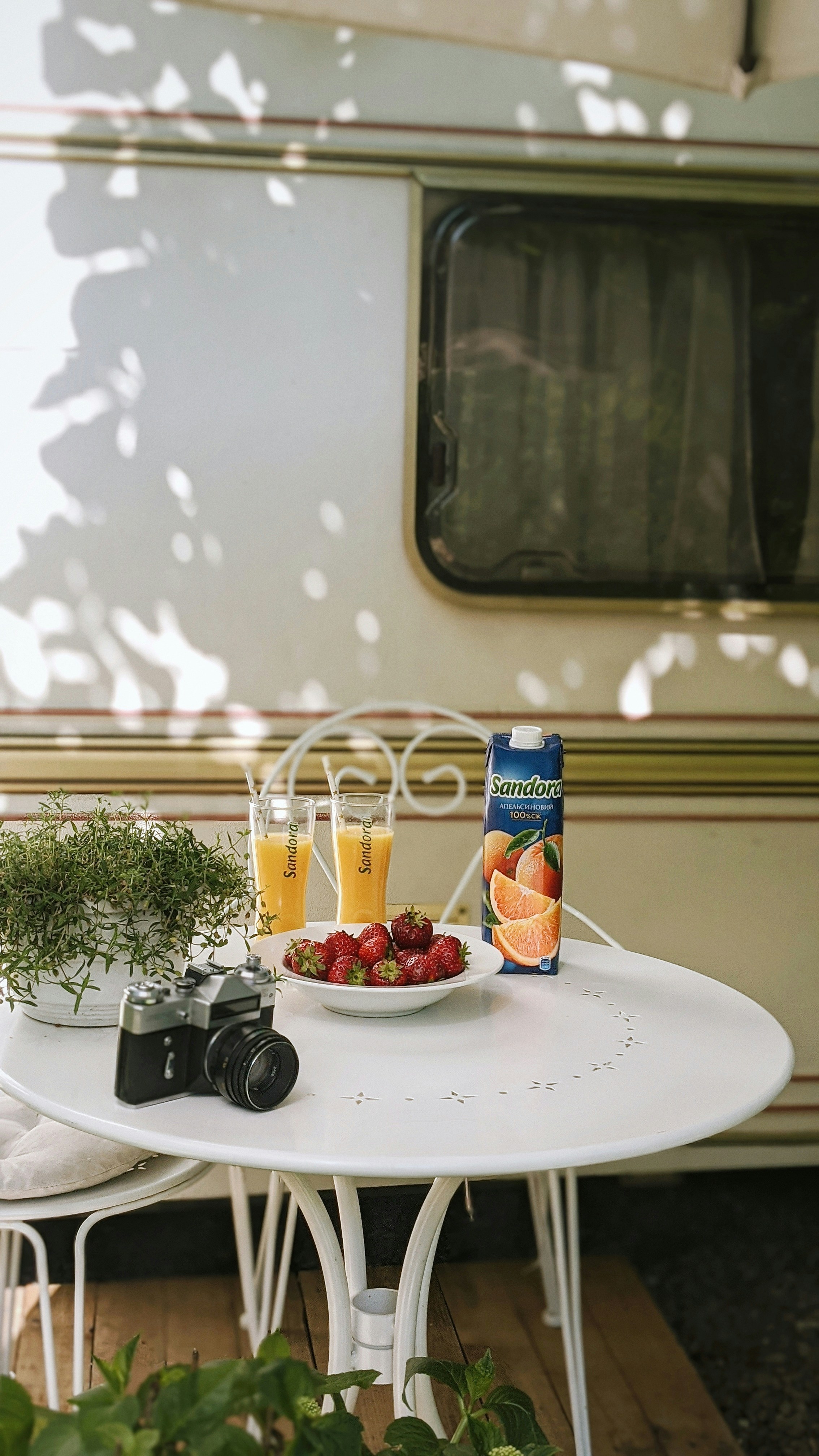 Une table avec une assiette de fruits et un sachet de jus d’orange ...