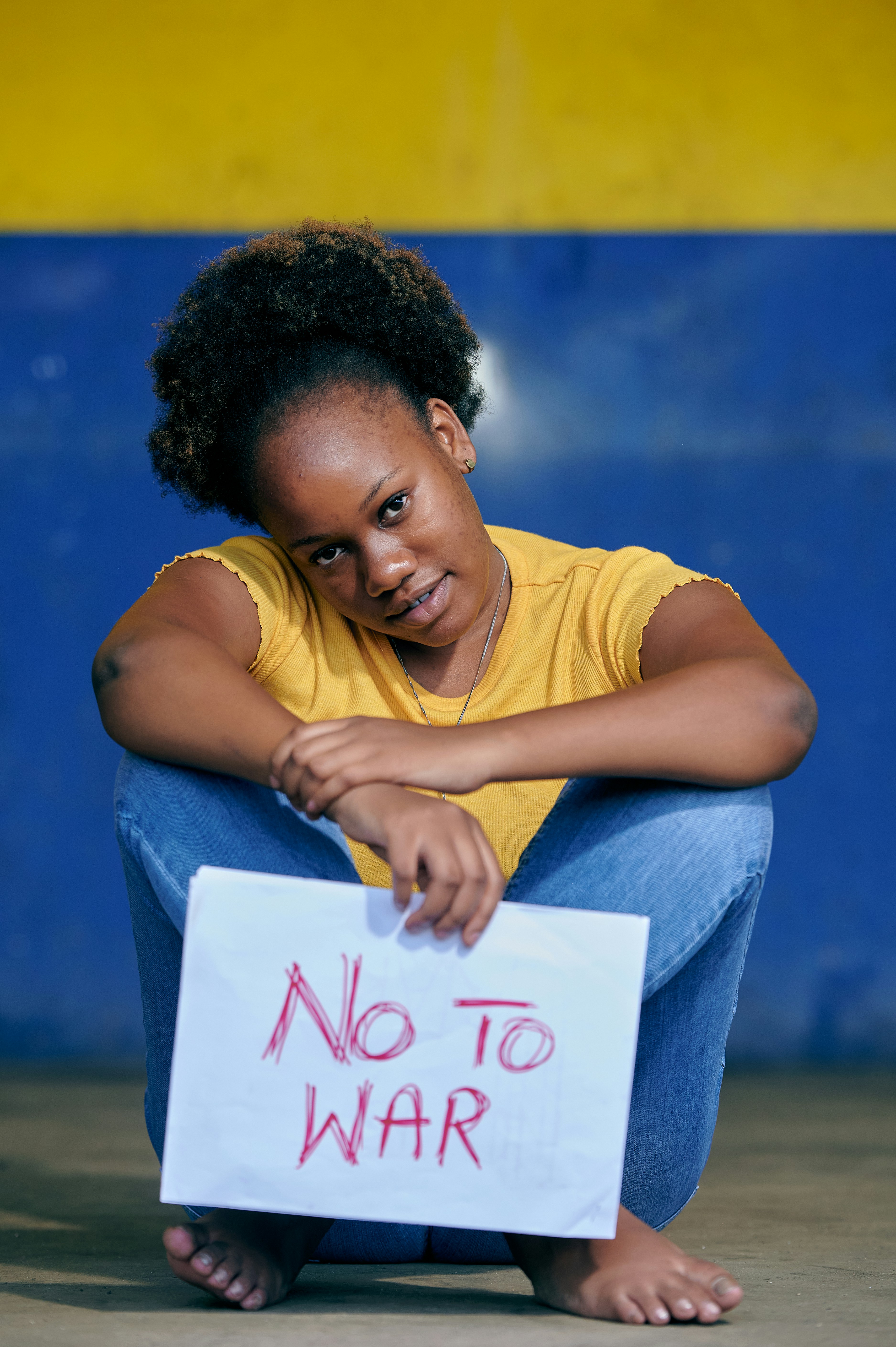 a woman holding a sign that says no to war