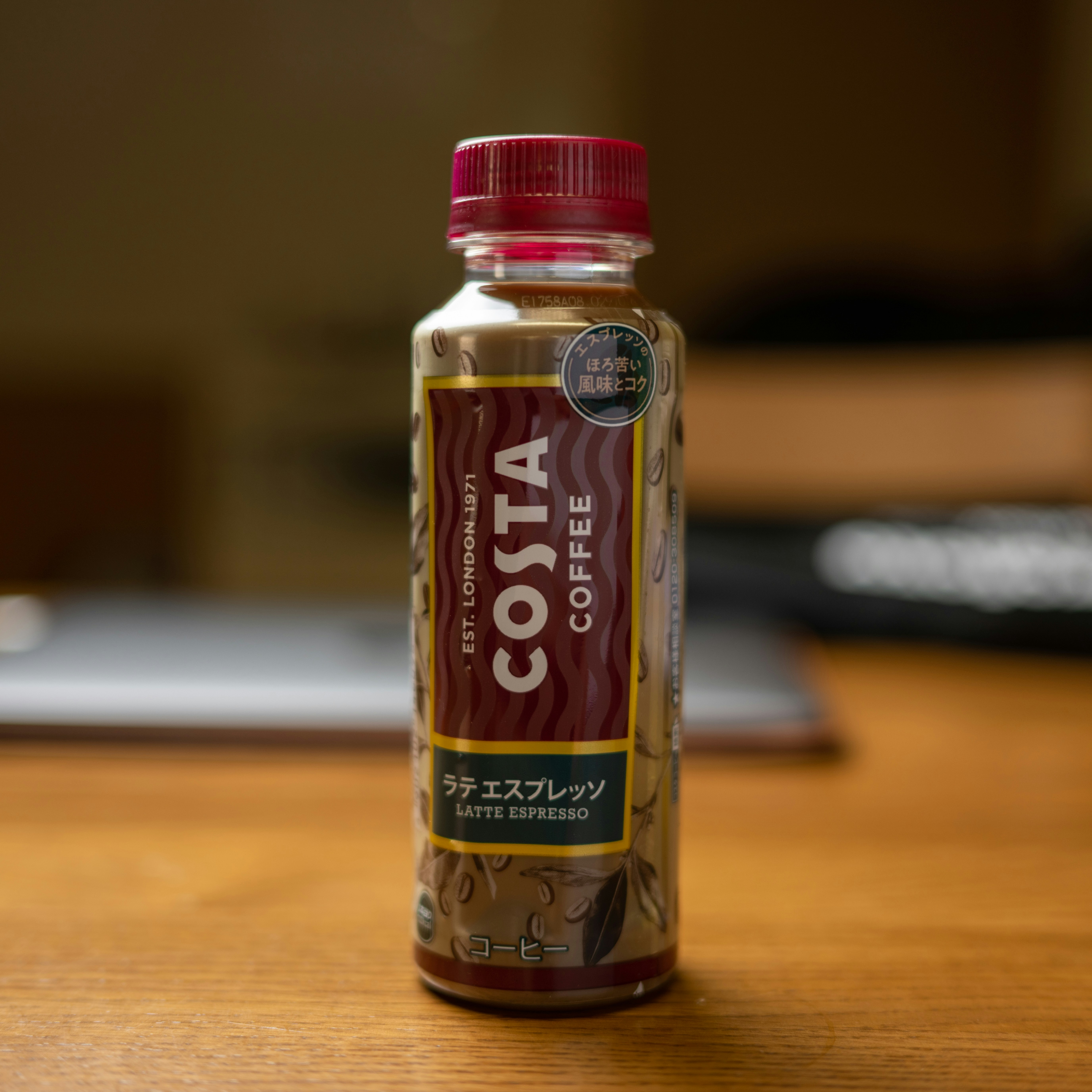 Foto Una botella de café encima de una mesa de madera – Imagen Botella ...