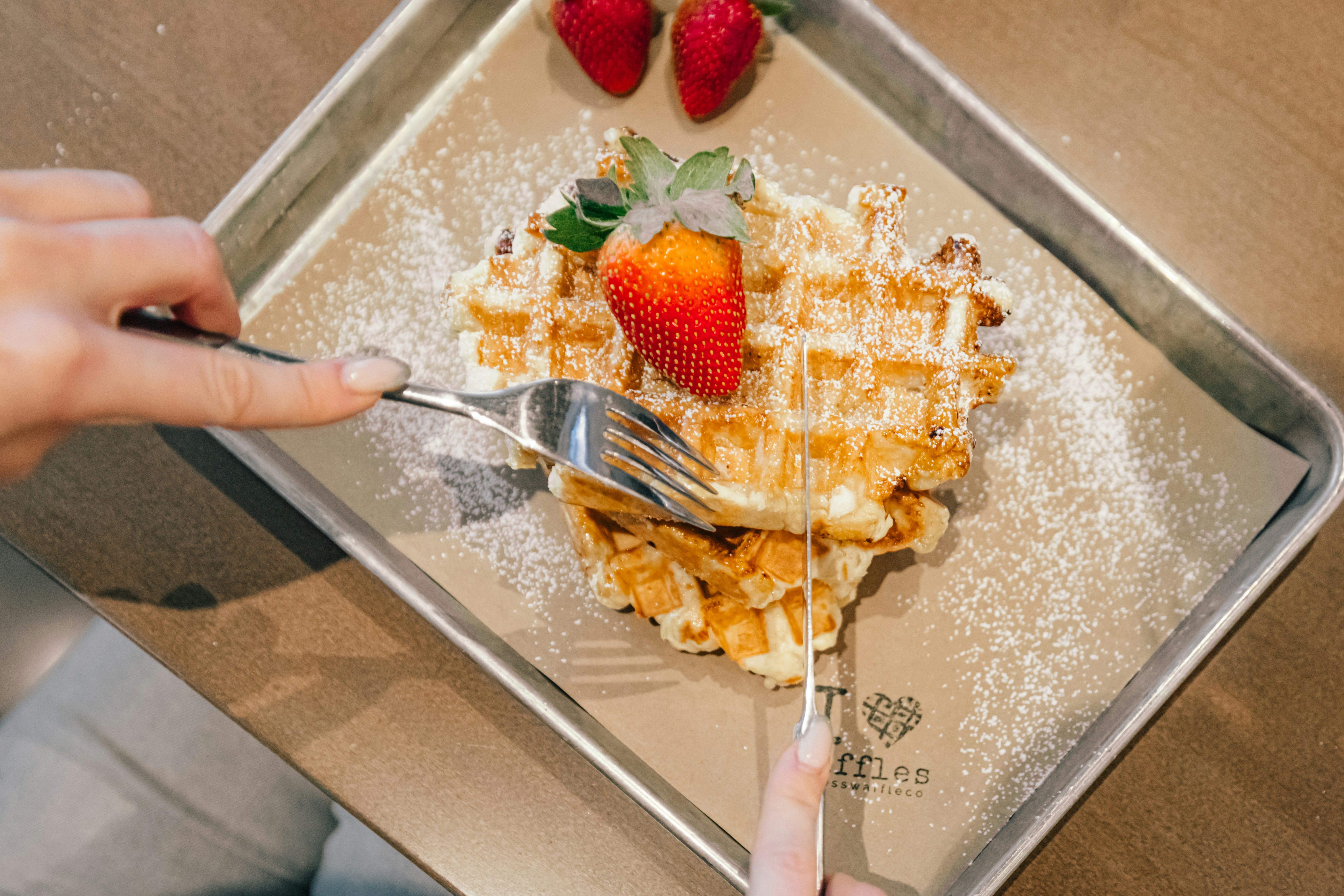 A person holding a fork and a plate of waffles photo – Free Waffle ...