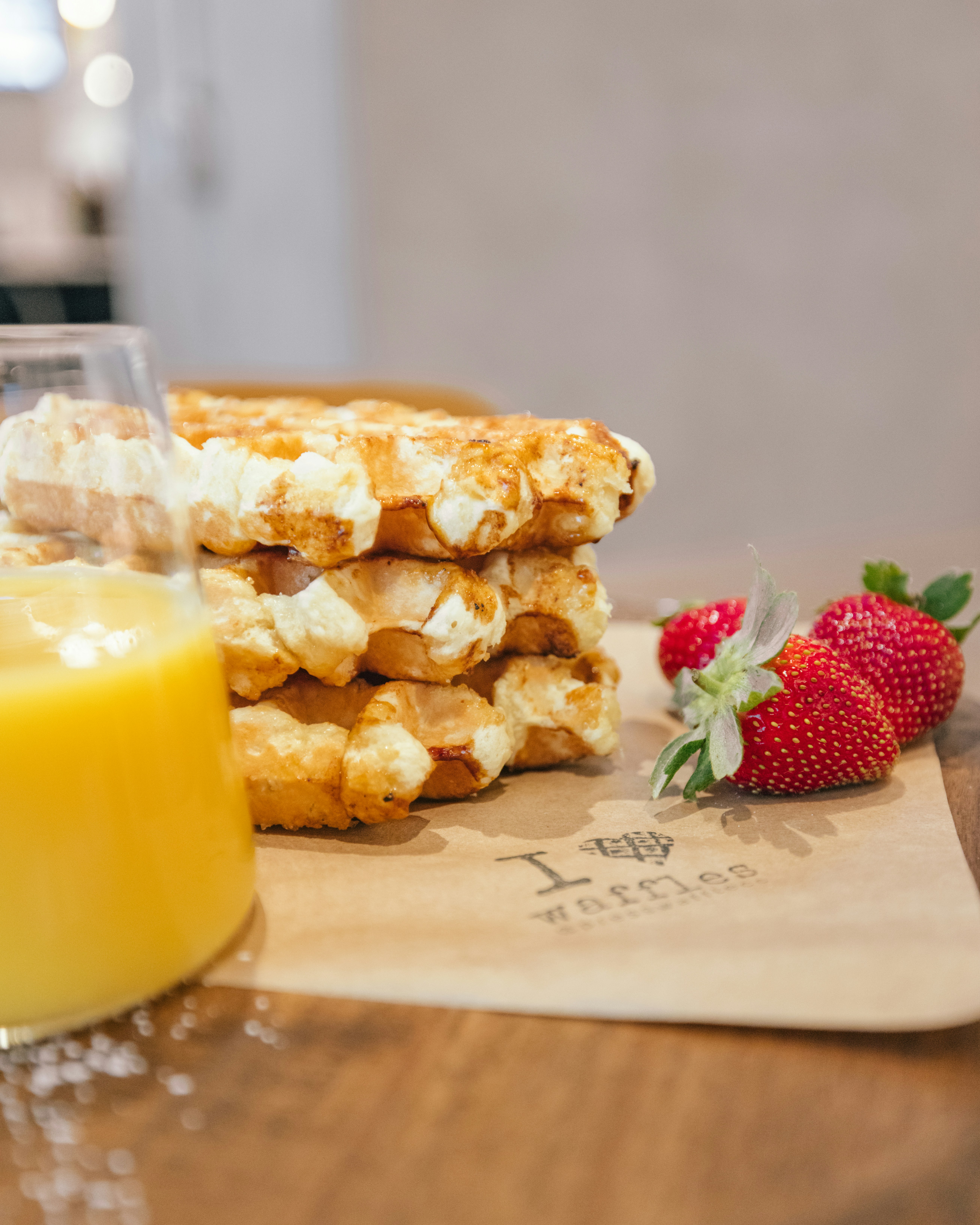 A stack of waffles next to a glass of orange juice photo – Free Waffle ...