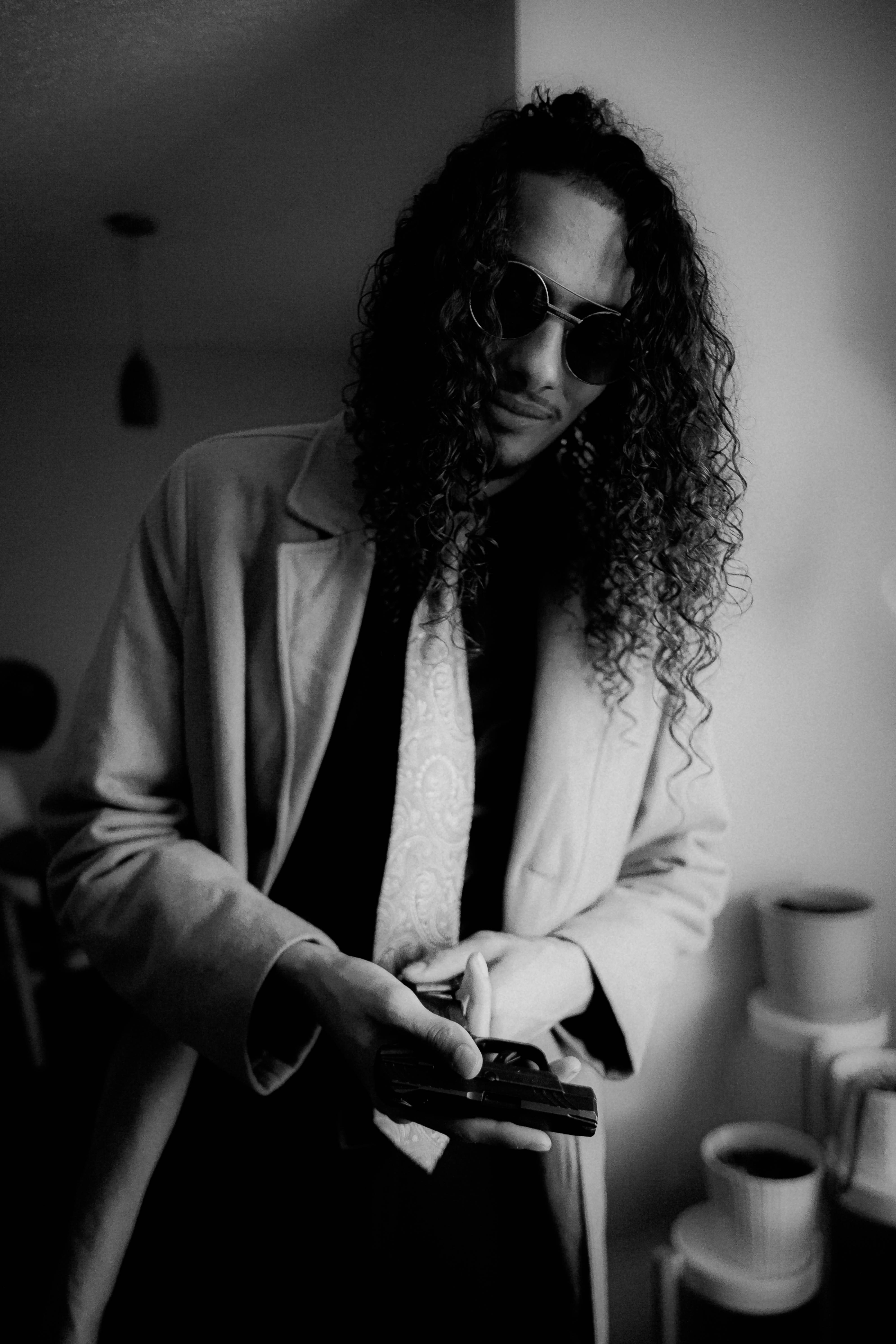 a black and white photo of a man holding a cell phone