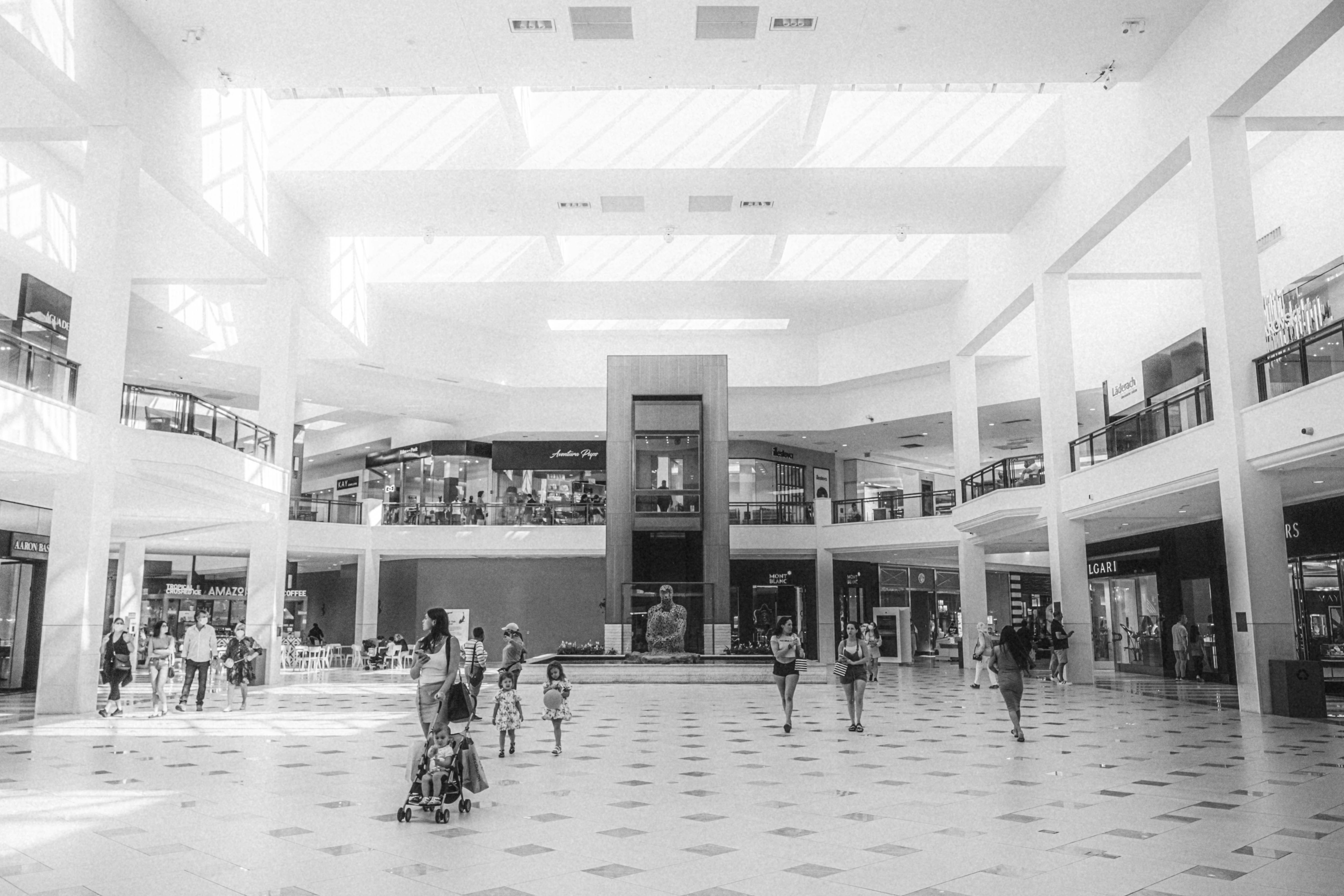 A black and white photo of people in a shopping mall photo – Free Grey ...