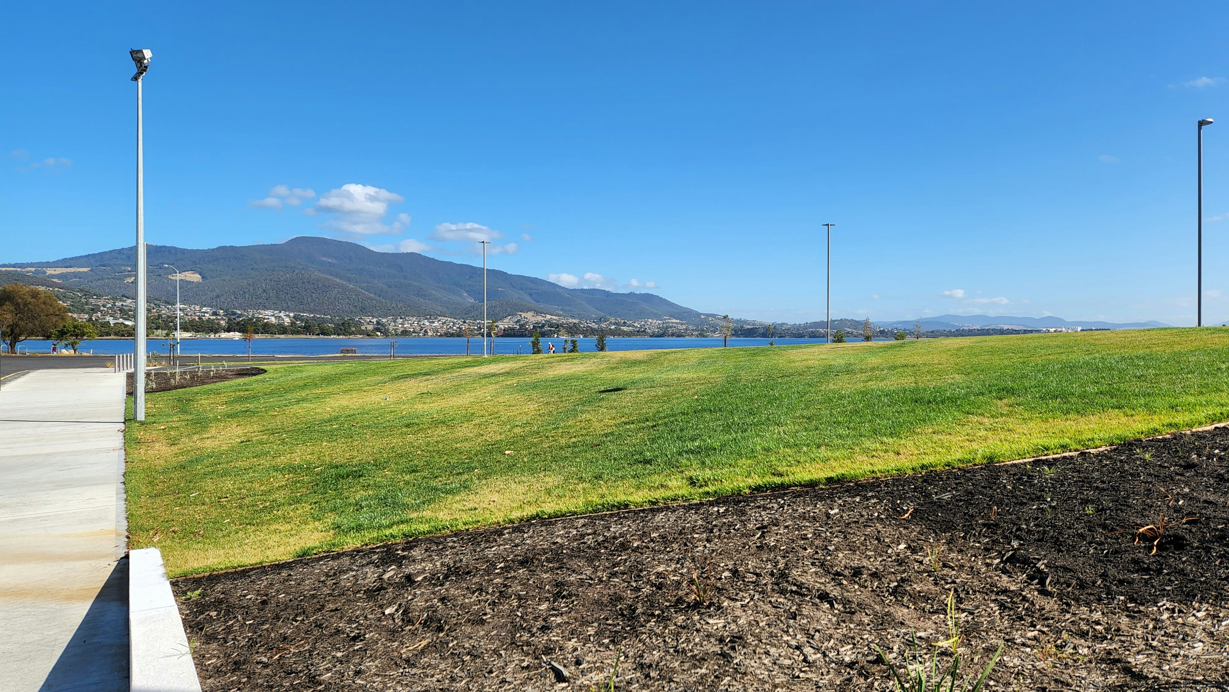 Blue Horizon Park: A Quiet Coastal Walk Framing Sea, Sky, and Distant Peaks