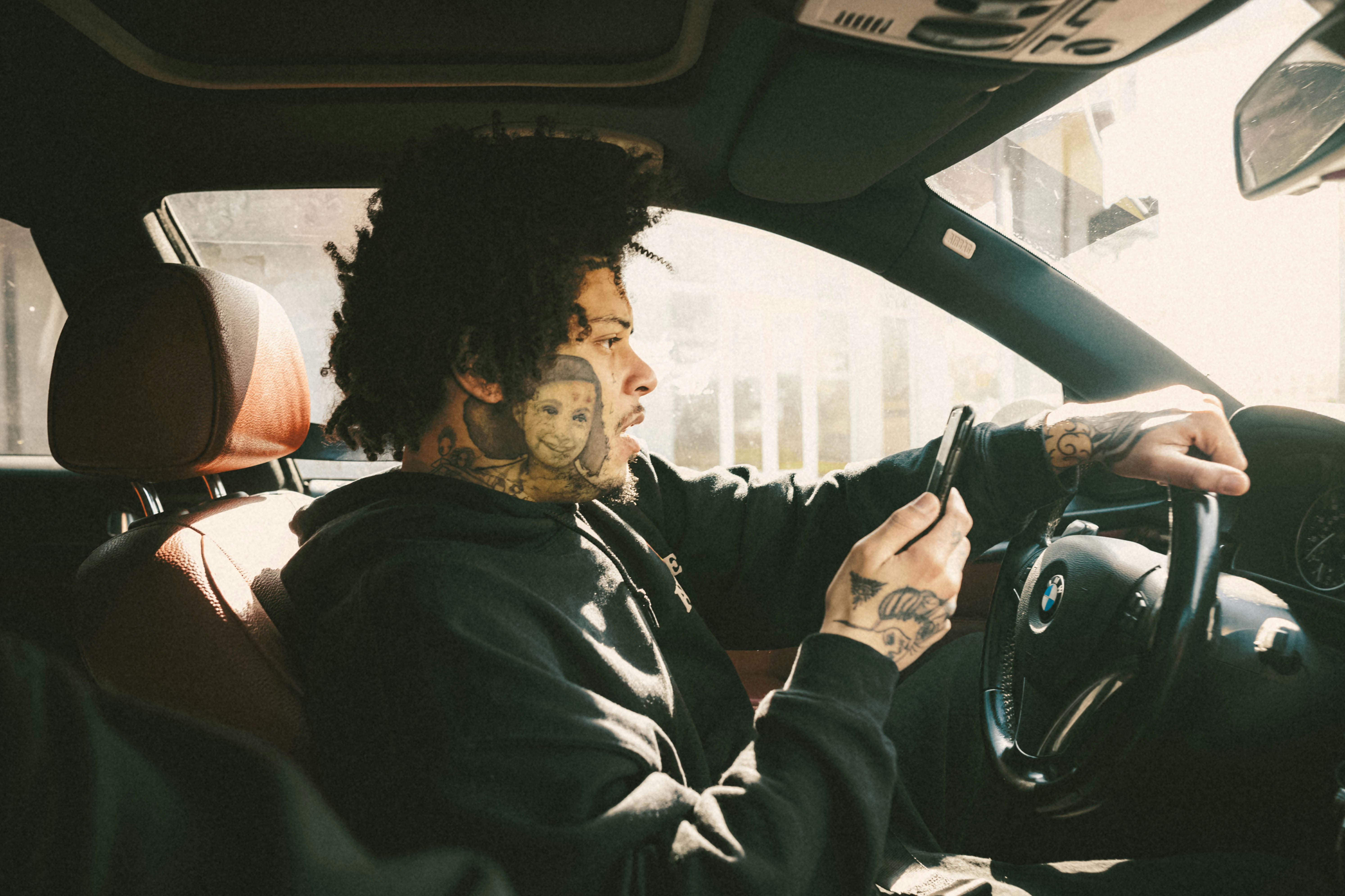 A man with tattoos on his face driving a car photo – Free Person Image ...
