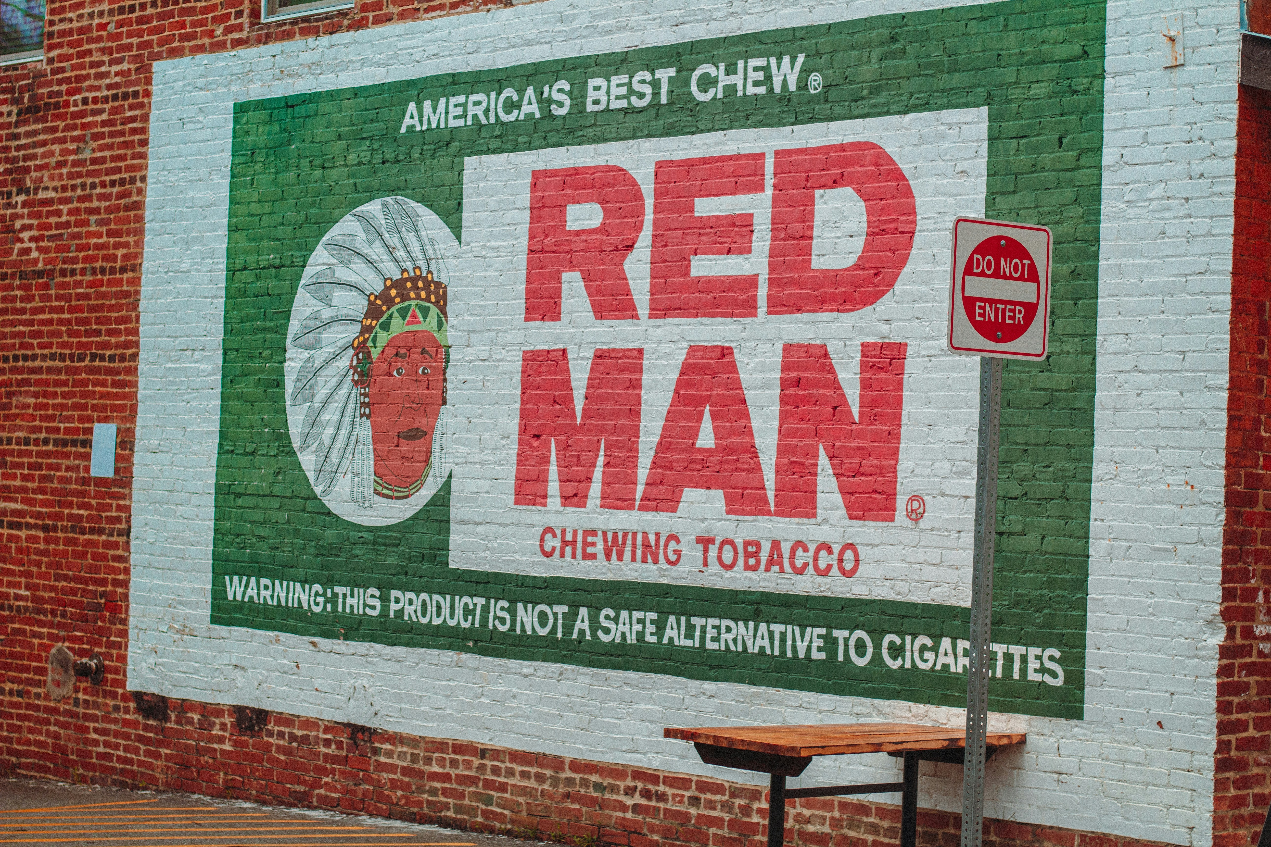 A red man sign on the side of a building photo – Free Blue ridge Image ...