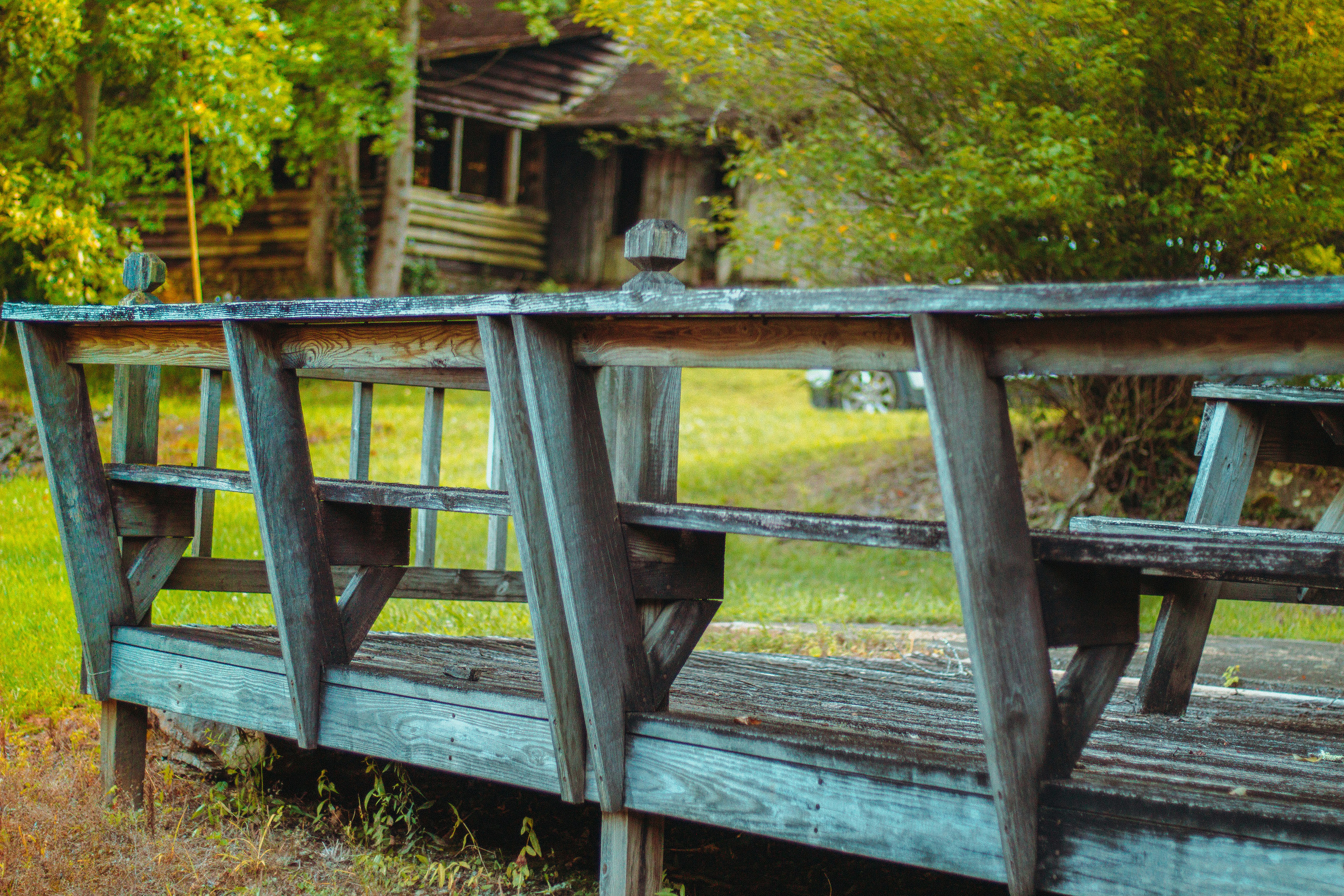 A wooden bench sitting on top of a lush green field photo – Free Ga ...