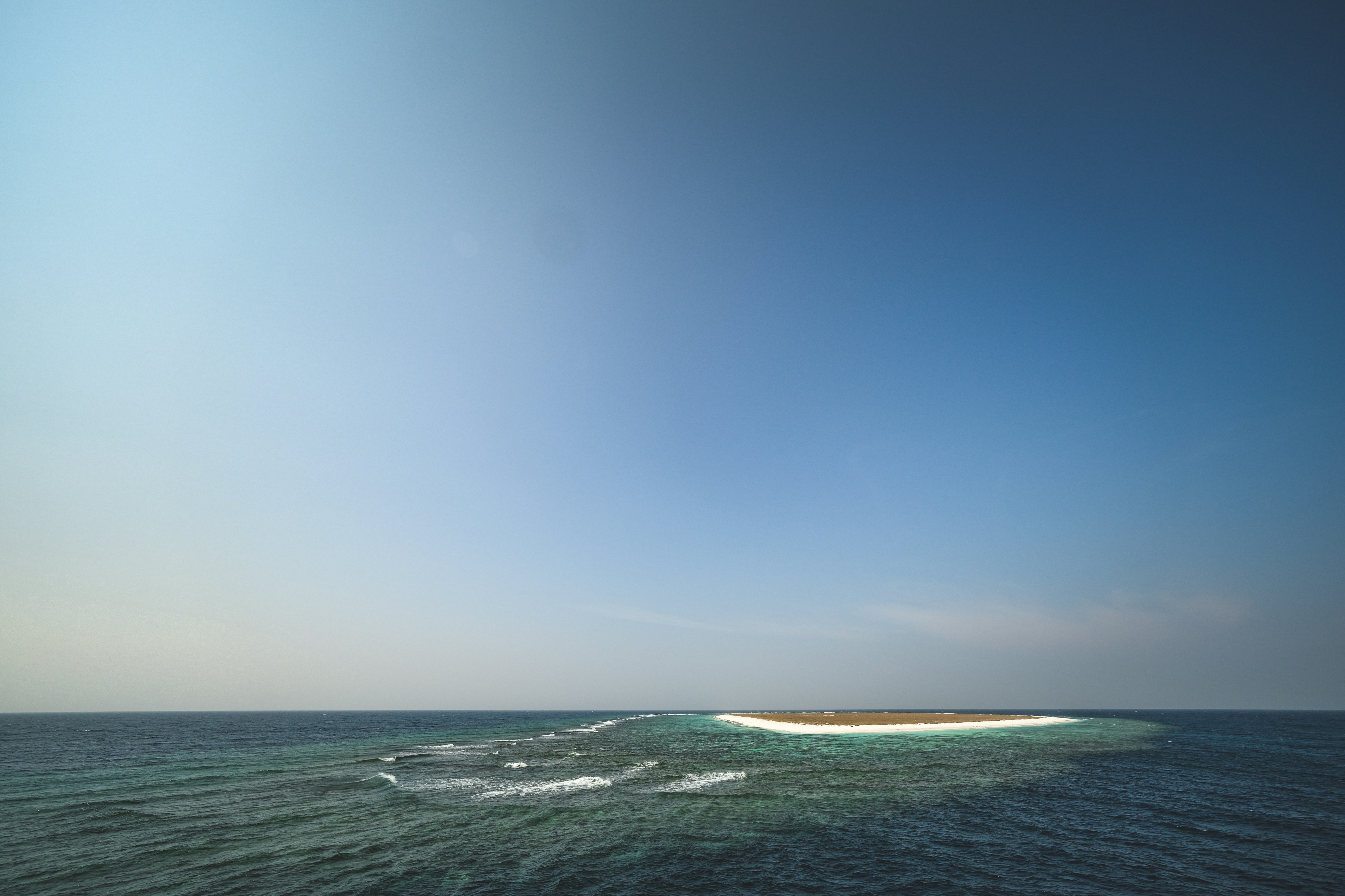 Sandbar at the Turquoise Edge: Shoreline Quiet Under a Cerulean Sky