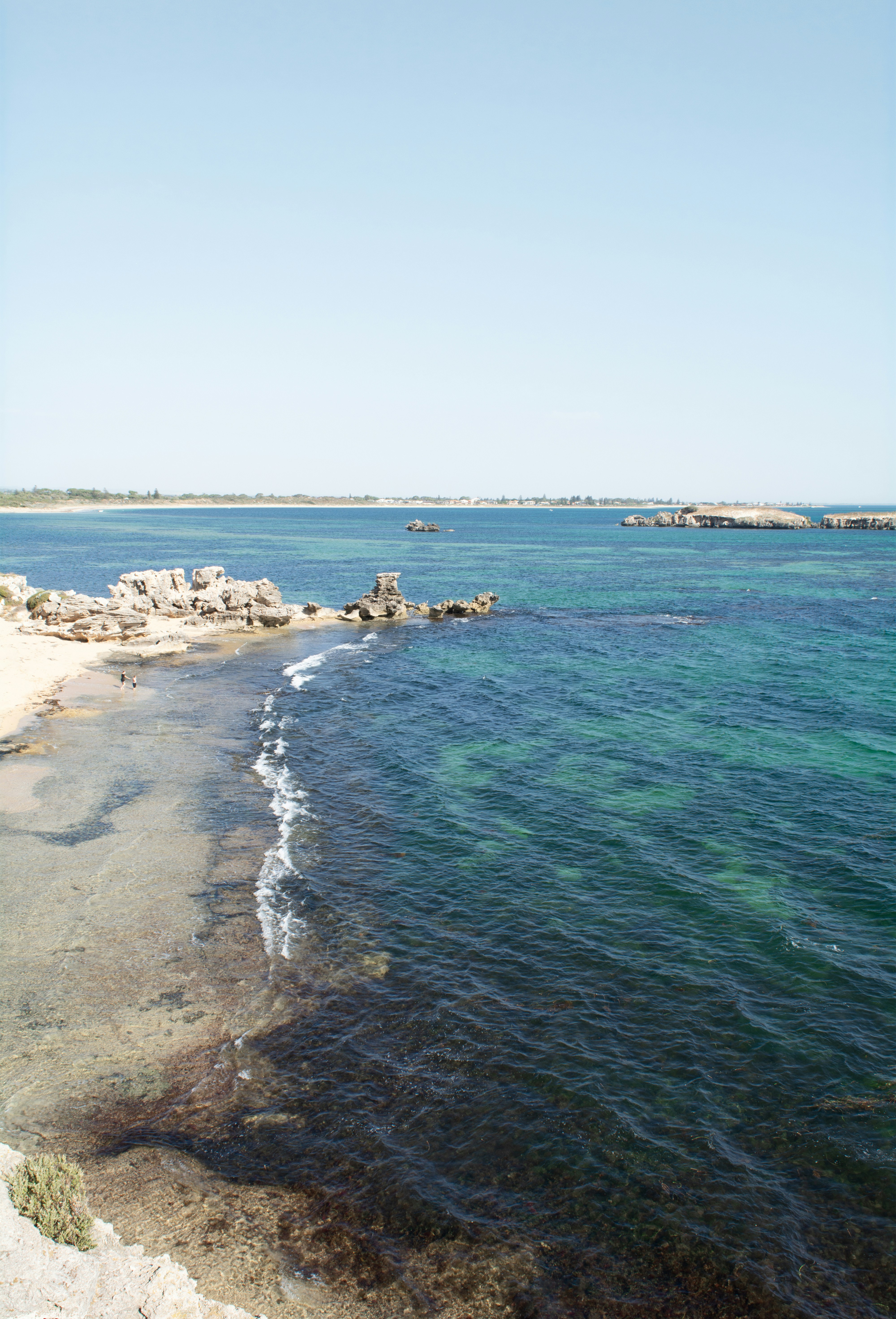 Quiet Coastal Edge: Crystal Waters and Rugged Rocks Meet the Horizon