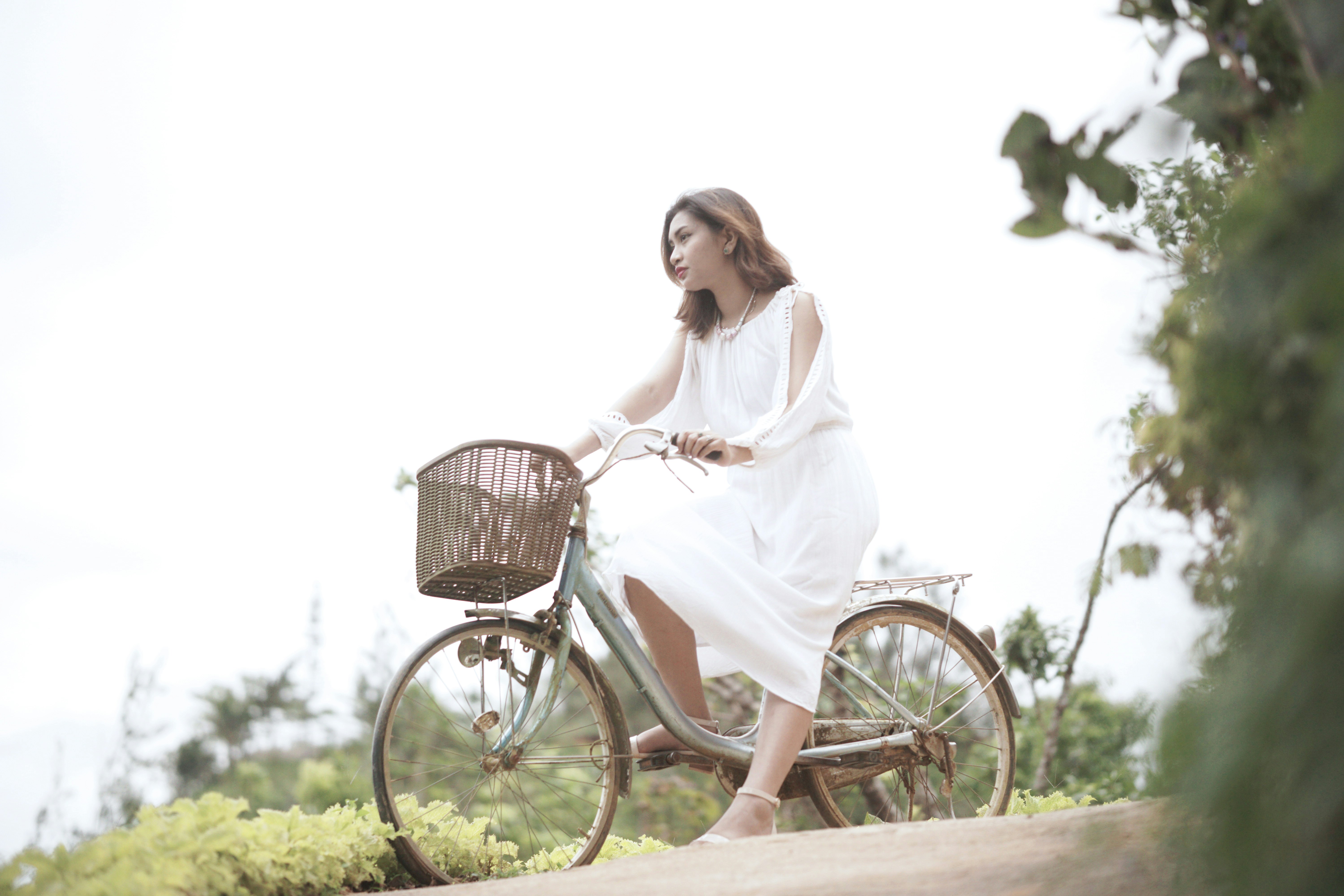 White-draped rider on a vintage bicycle under soft daylight