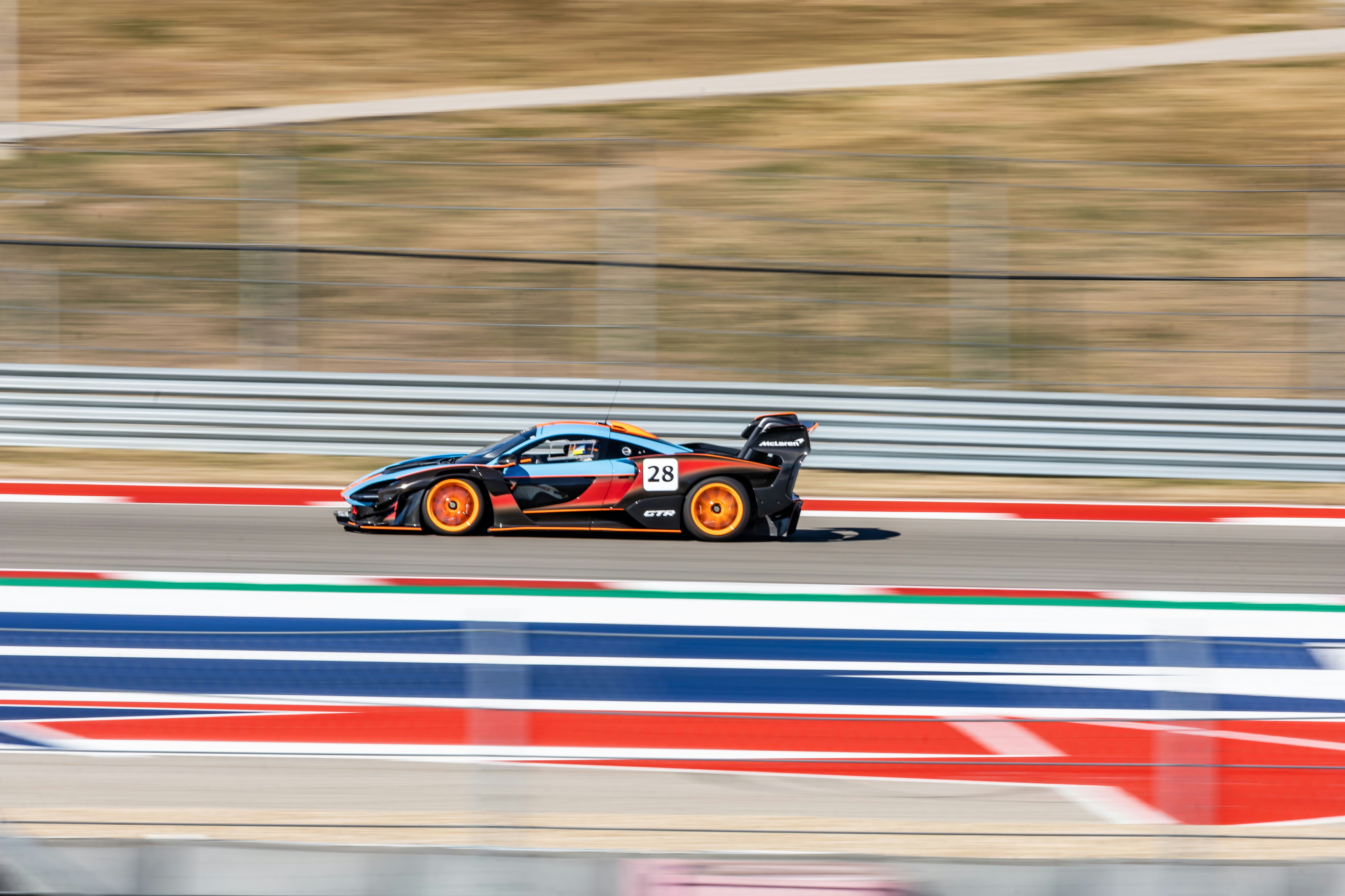 A race car driving on a race track photo – Free Car Image on Unsplash