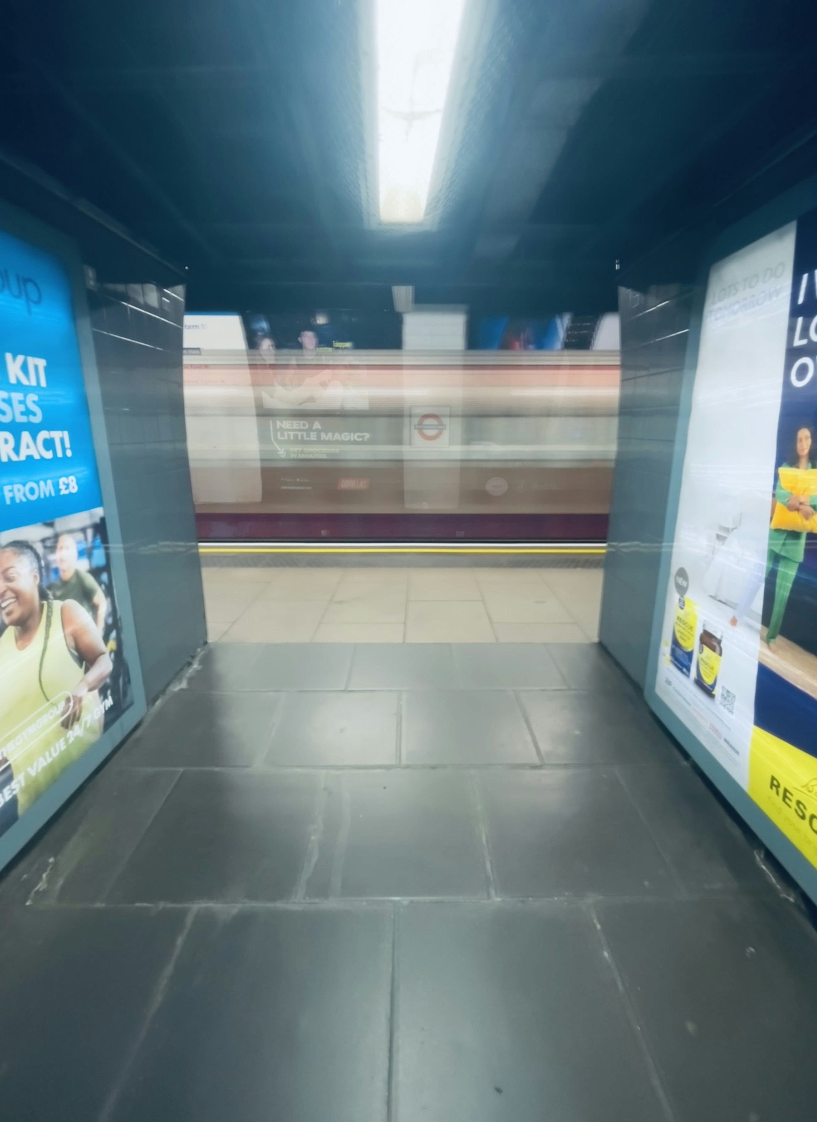 A subway station with posters on the wall photo – Free London Image on ...