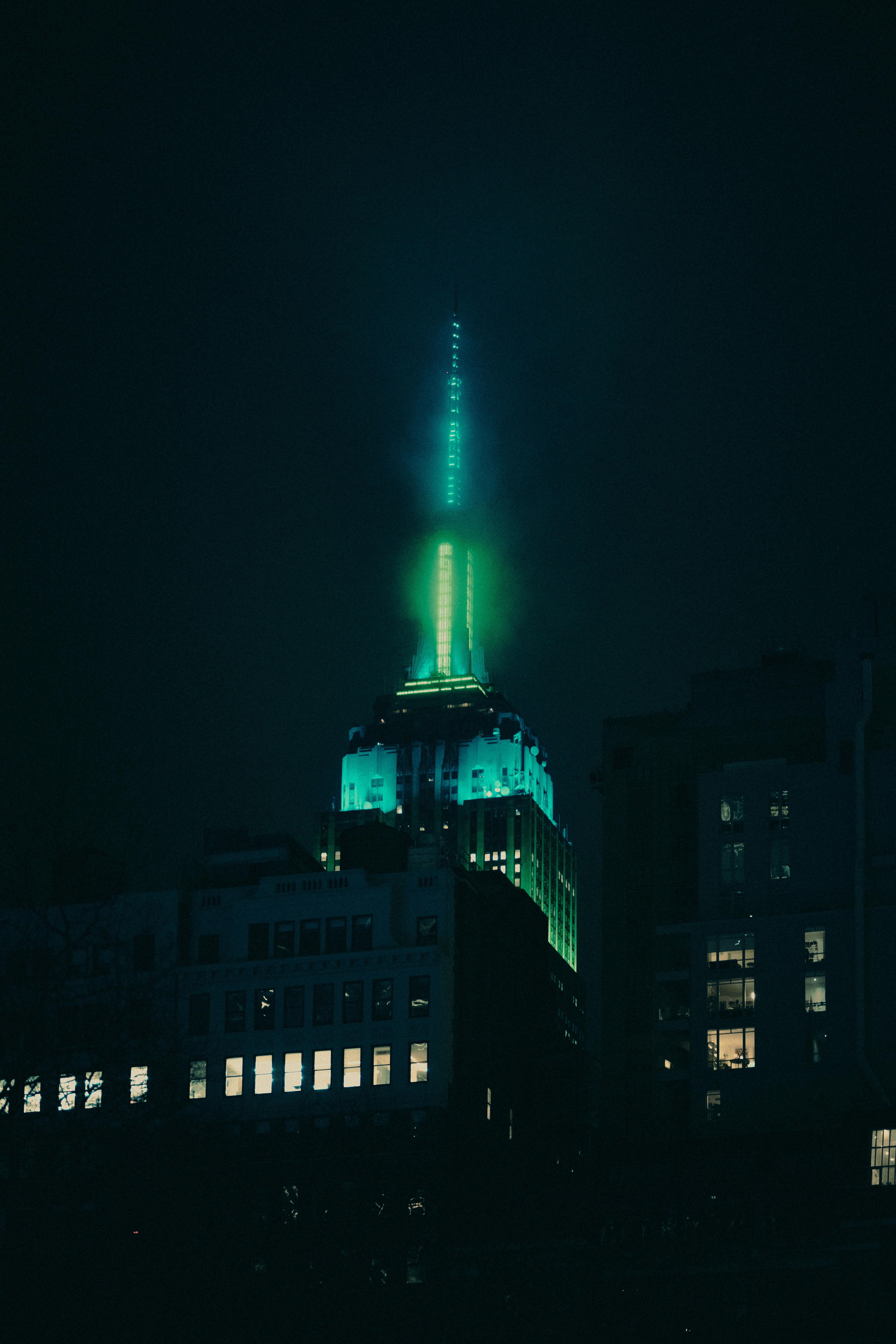 a very tall building with a green light on top of it