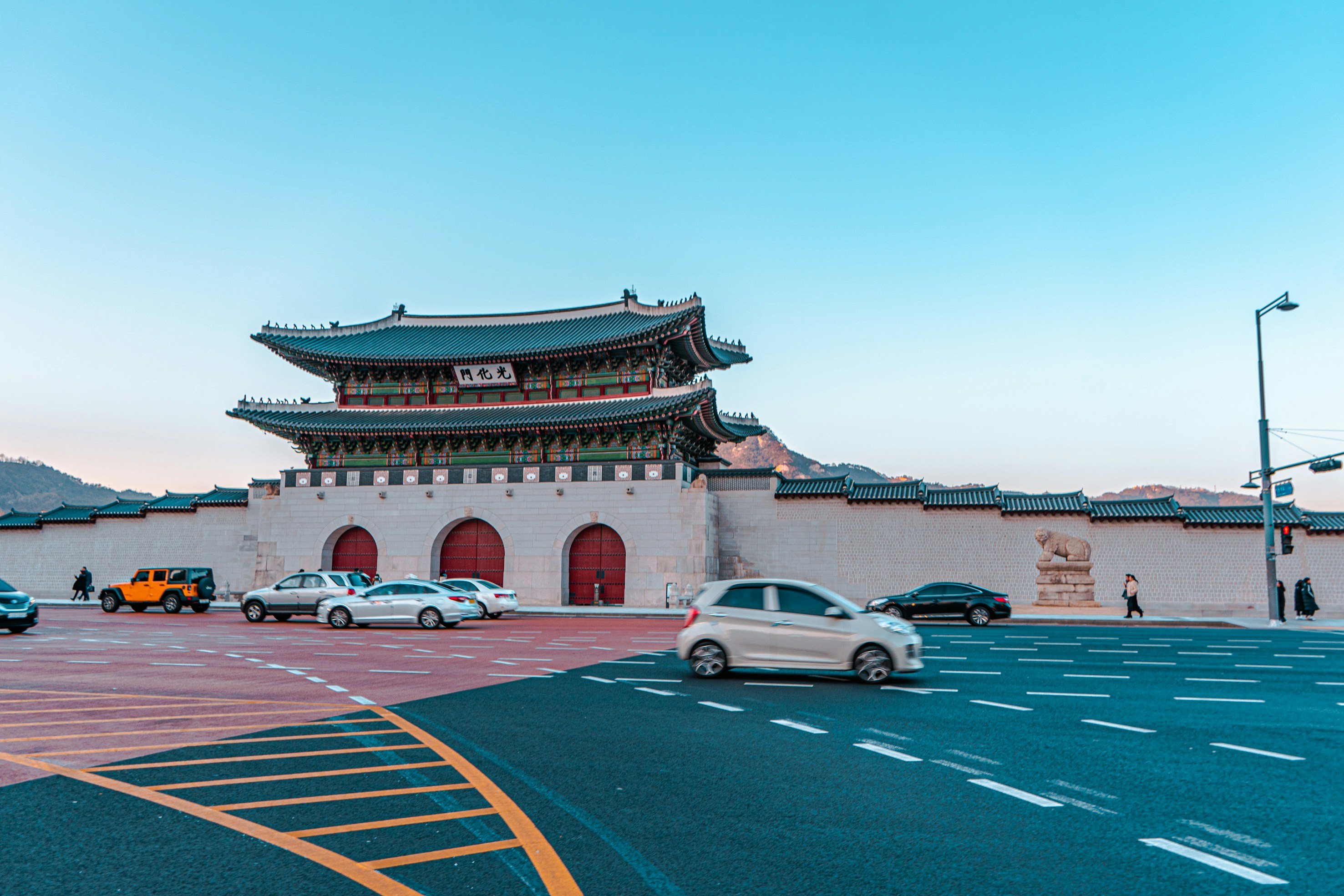 View from the avenue to Gwanghwamun entrance  | cars are parked in front of a building