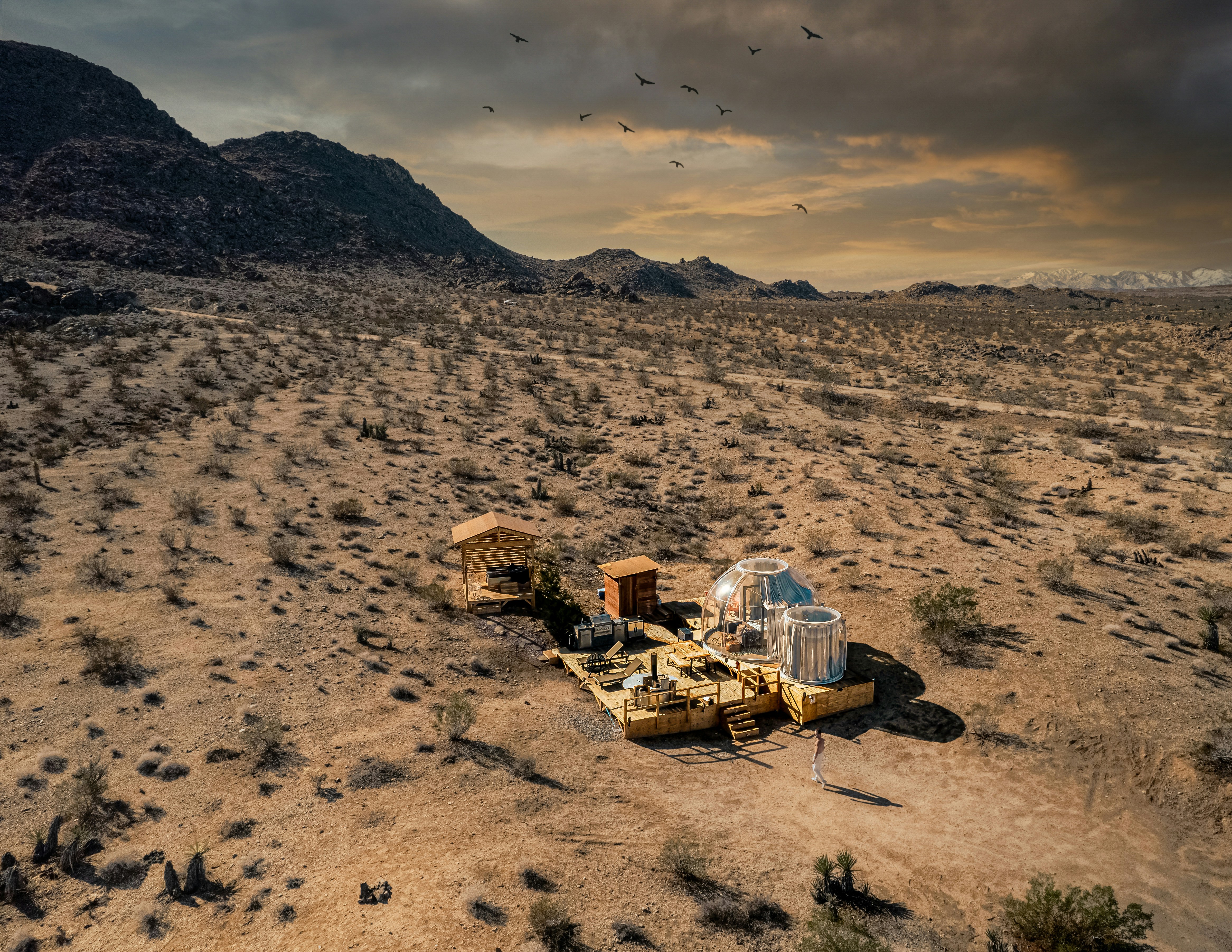 A desert scene with a small structure in the middle of the desert photo ...