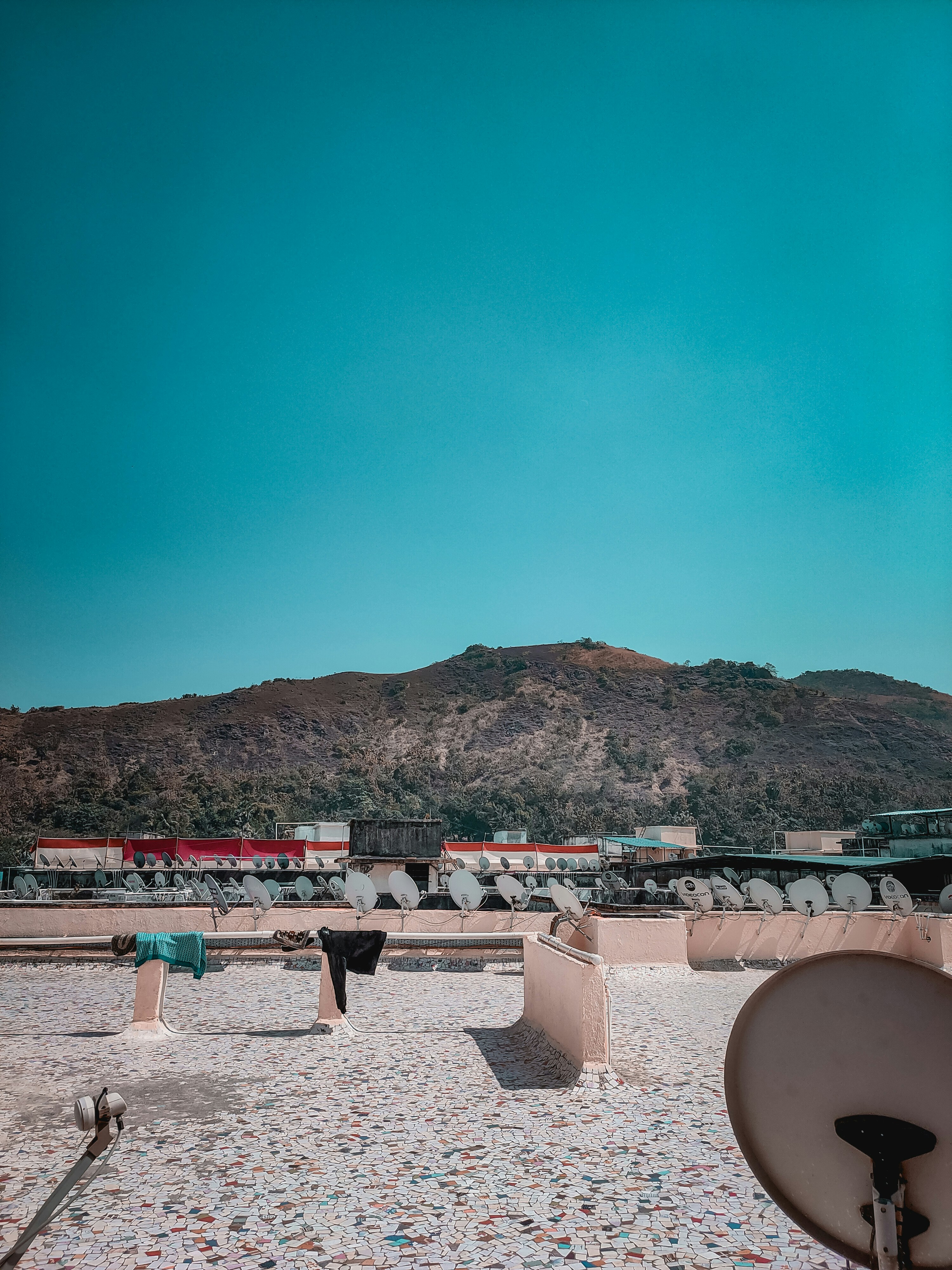 Turquoise Sky Over a Rooftop Terrace with Satellite Dishes
