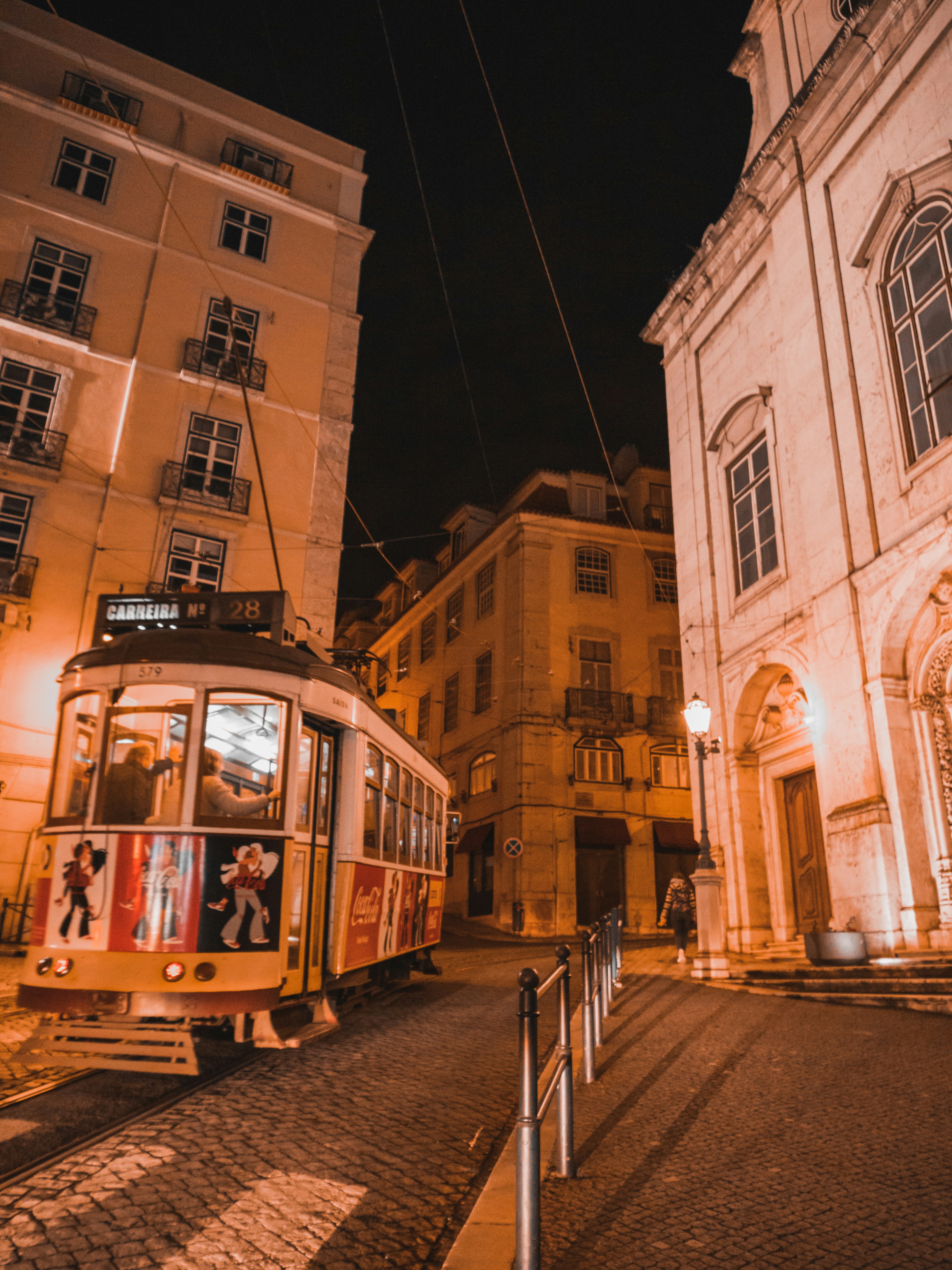 Lantern-lit Night: A Vintage Tram on Cobblestone Streets
