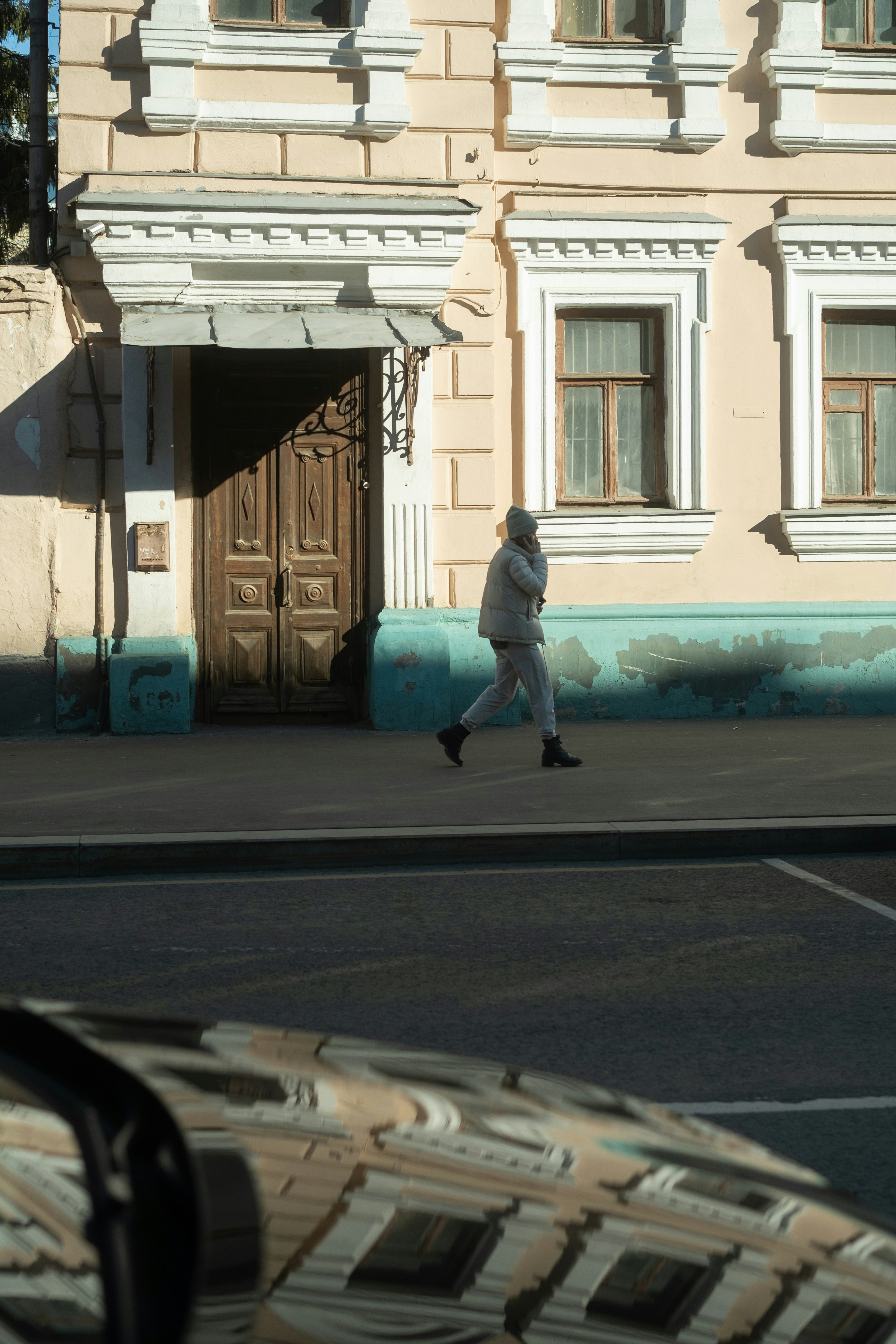 a man walking down the street in front of a building