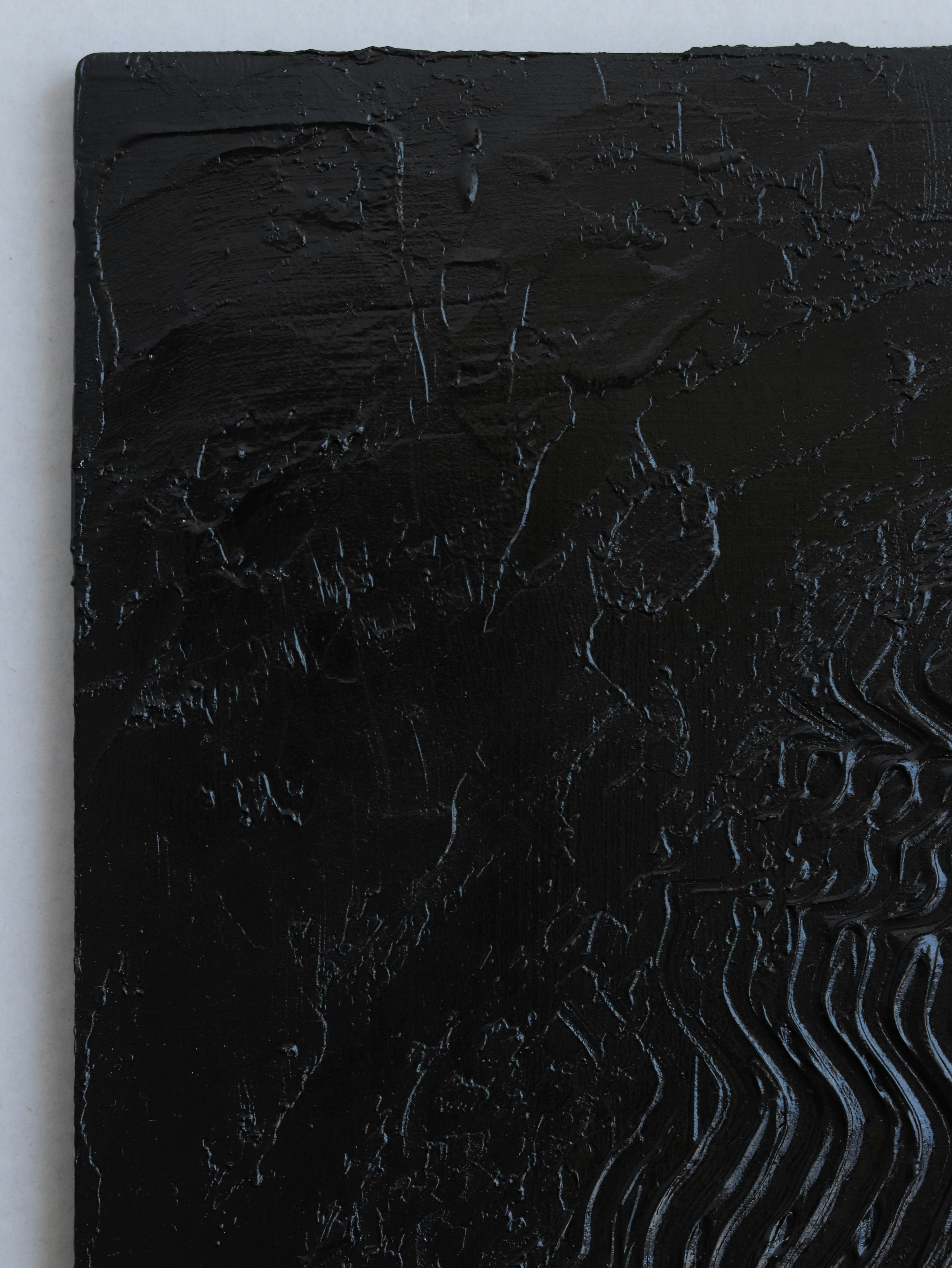 Abstract black surface featuring intricate textures and patterns, evoking a sense of depth and mystery.