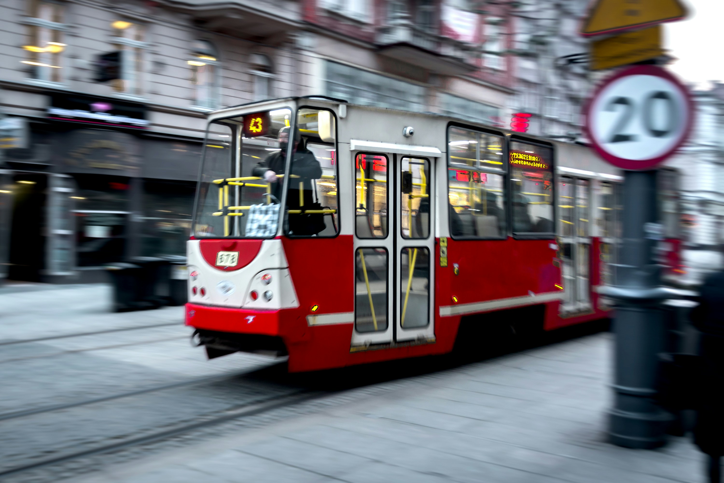 A red and white trolley on a city street photo – Free Tram Image on ...