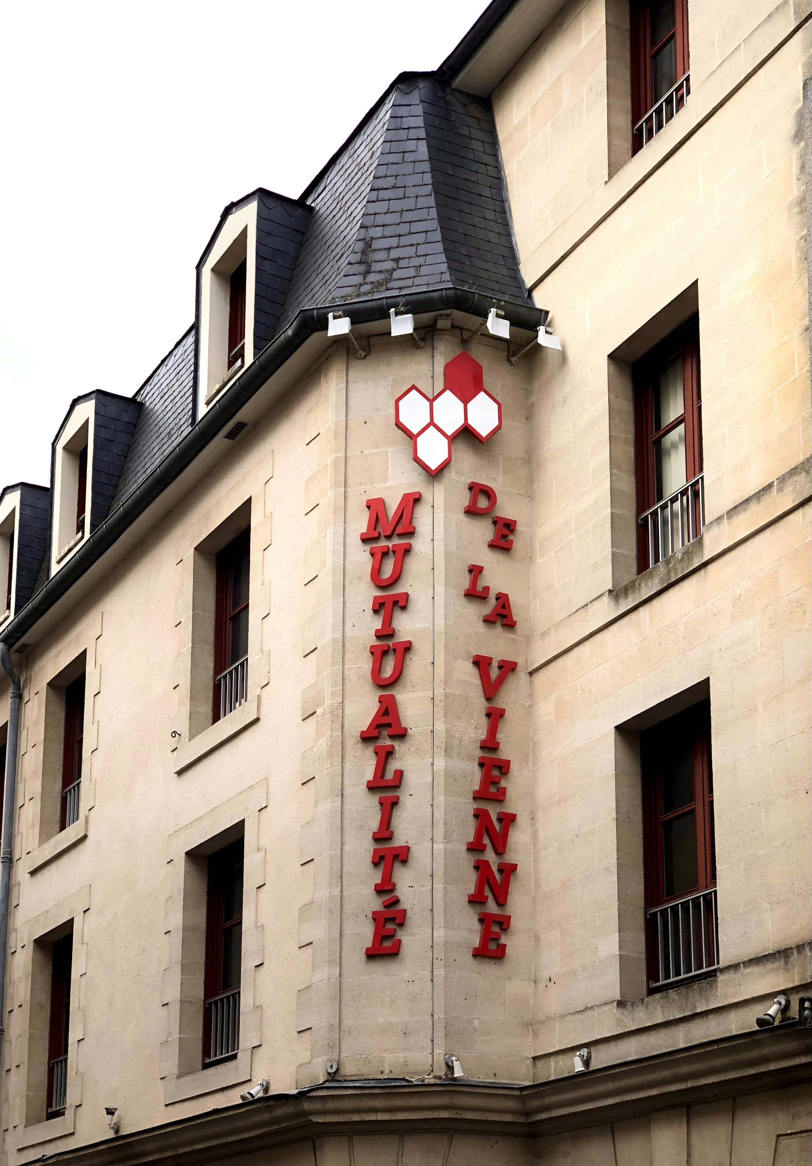 A tall building with a clock on the side of it photo – Free Business ...