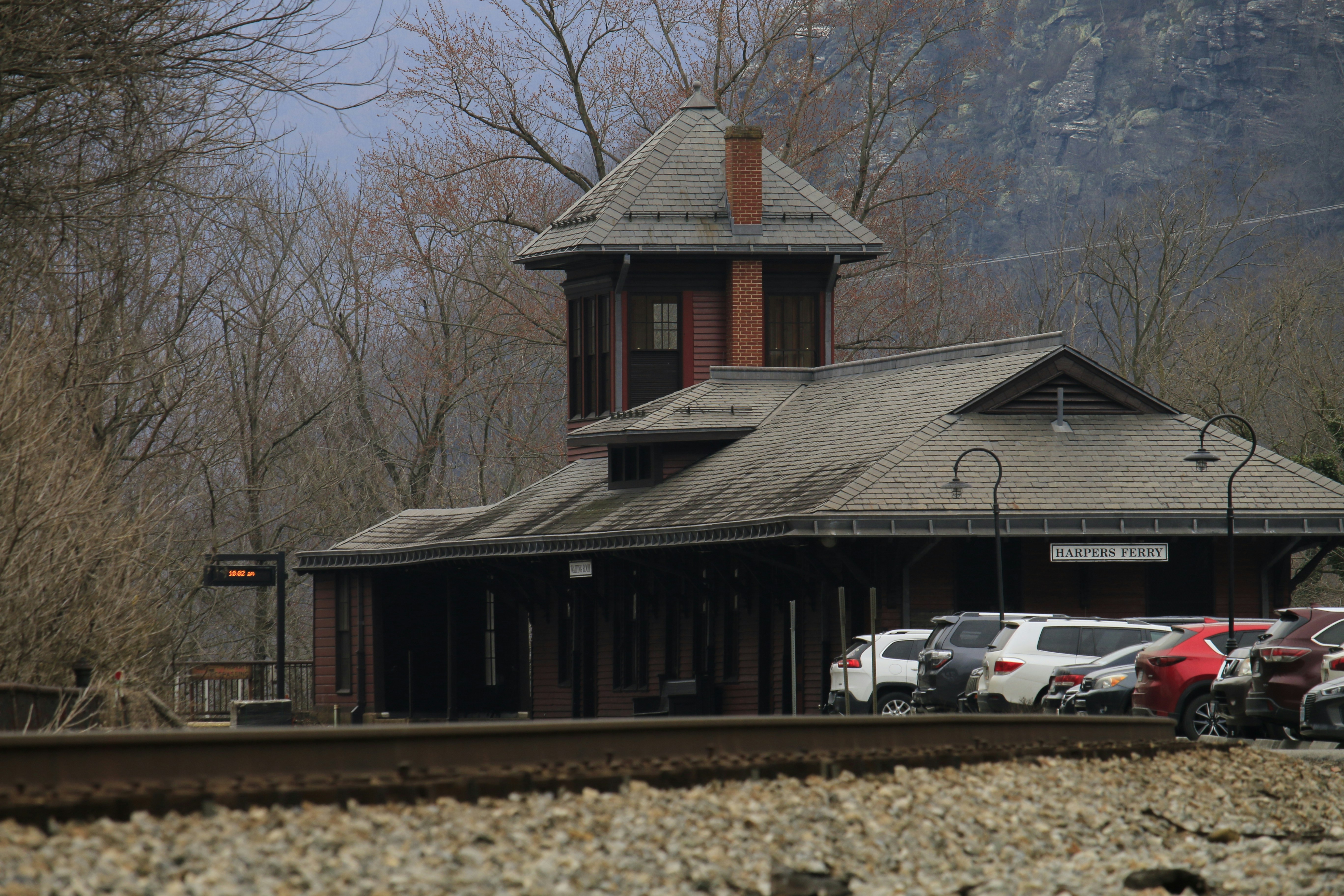 A train station with cars parked in front of it photo – Free Usa Image ...
