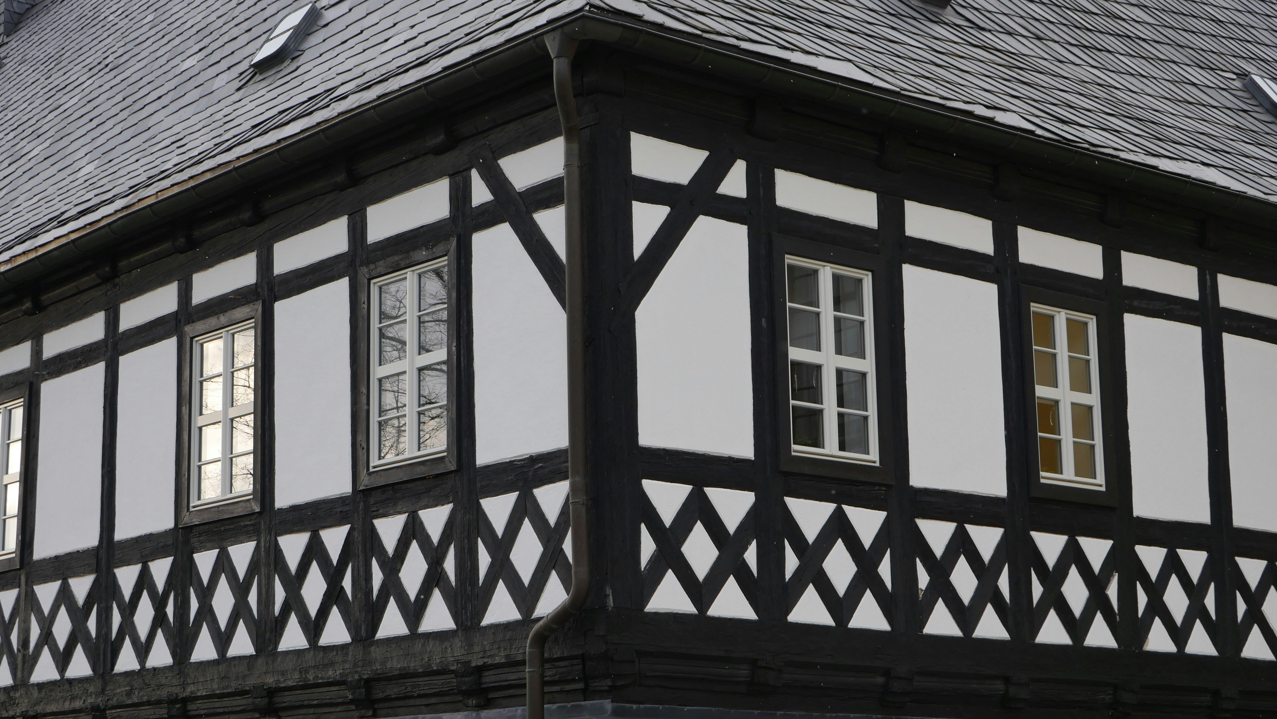 Half-timbered building showcasing intricate wooden framework and contrasting white walls, highlighting traditional architectural craftsmanship.
