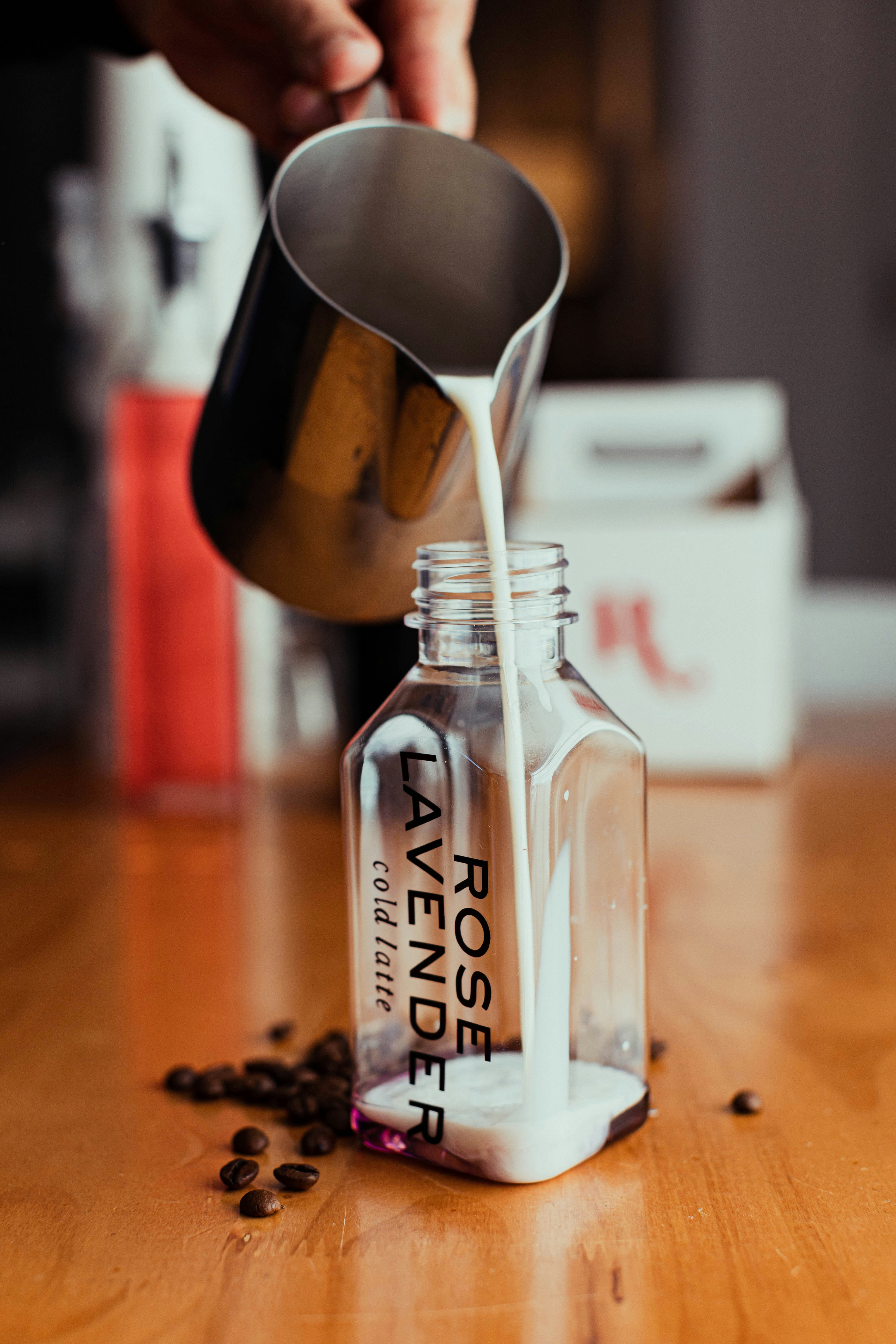 a person pouring coffee into a glass bottle