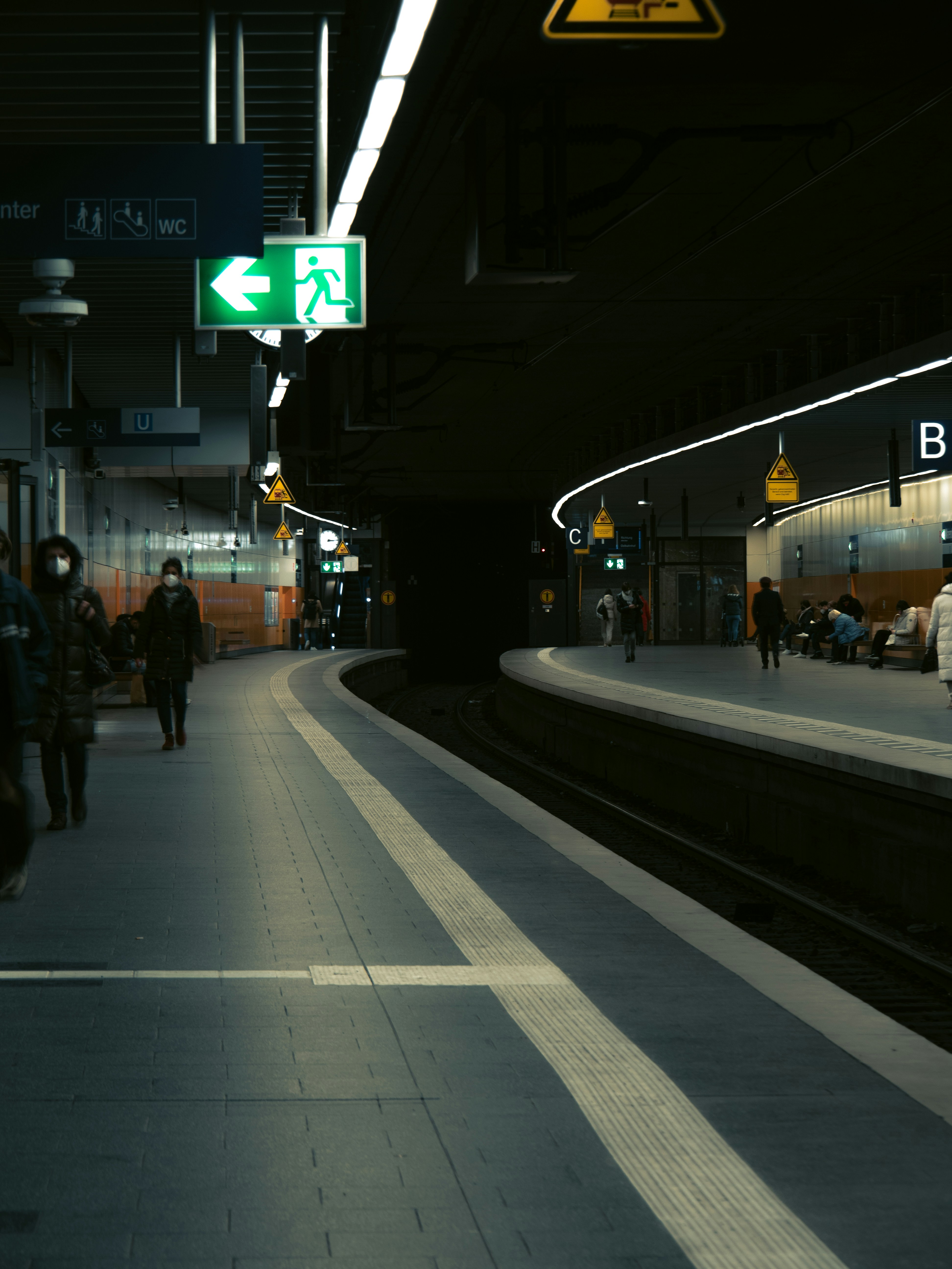 a train station with people walking on the platform