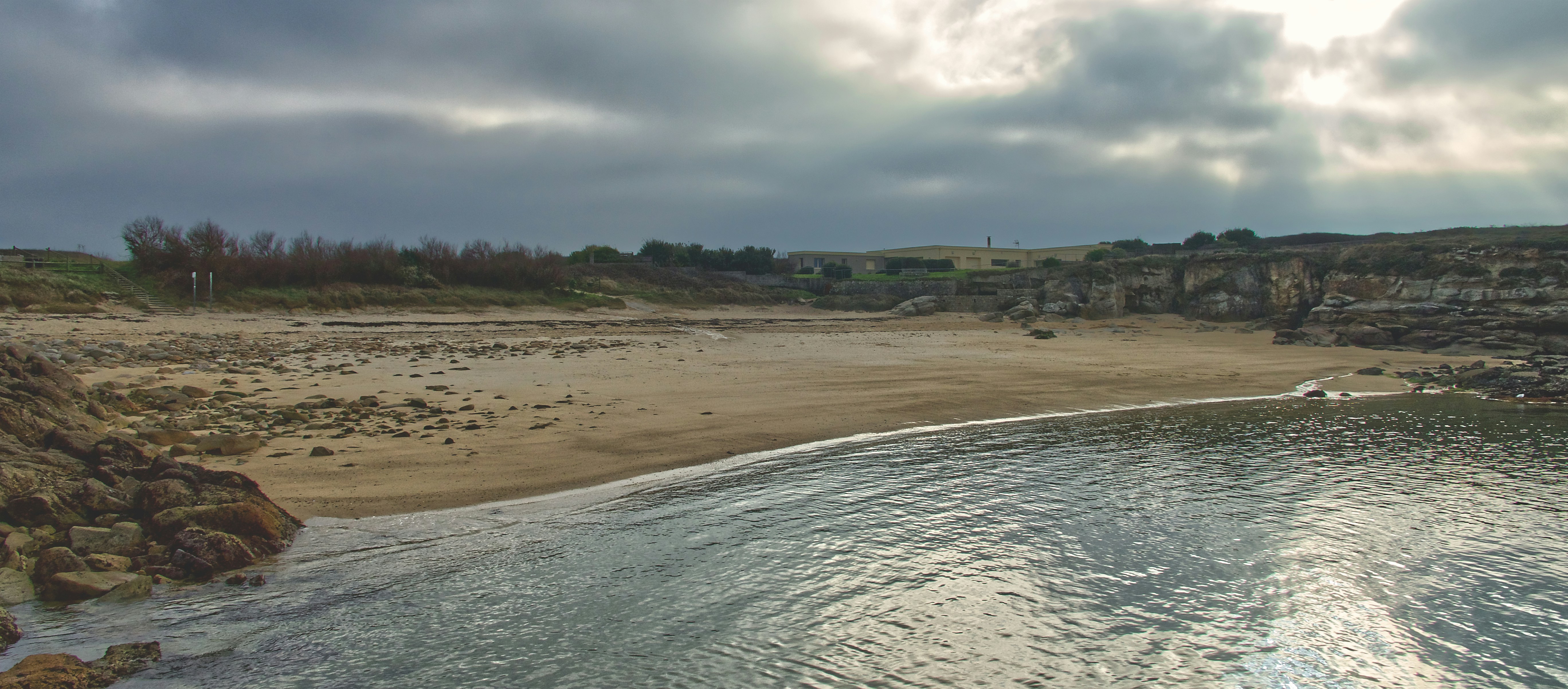 Ridge and Ripple: Quiet Cove Beneath Cloudy Skies