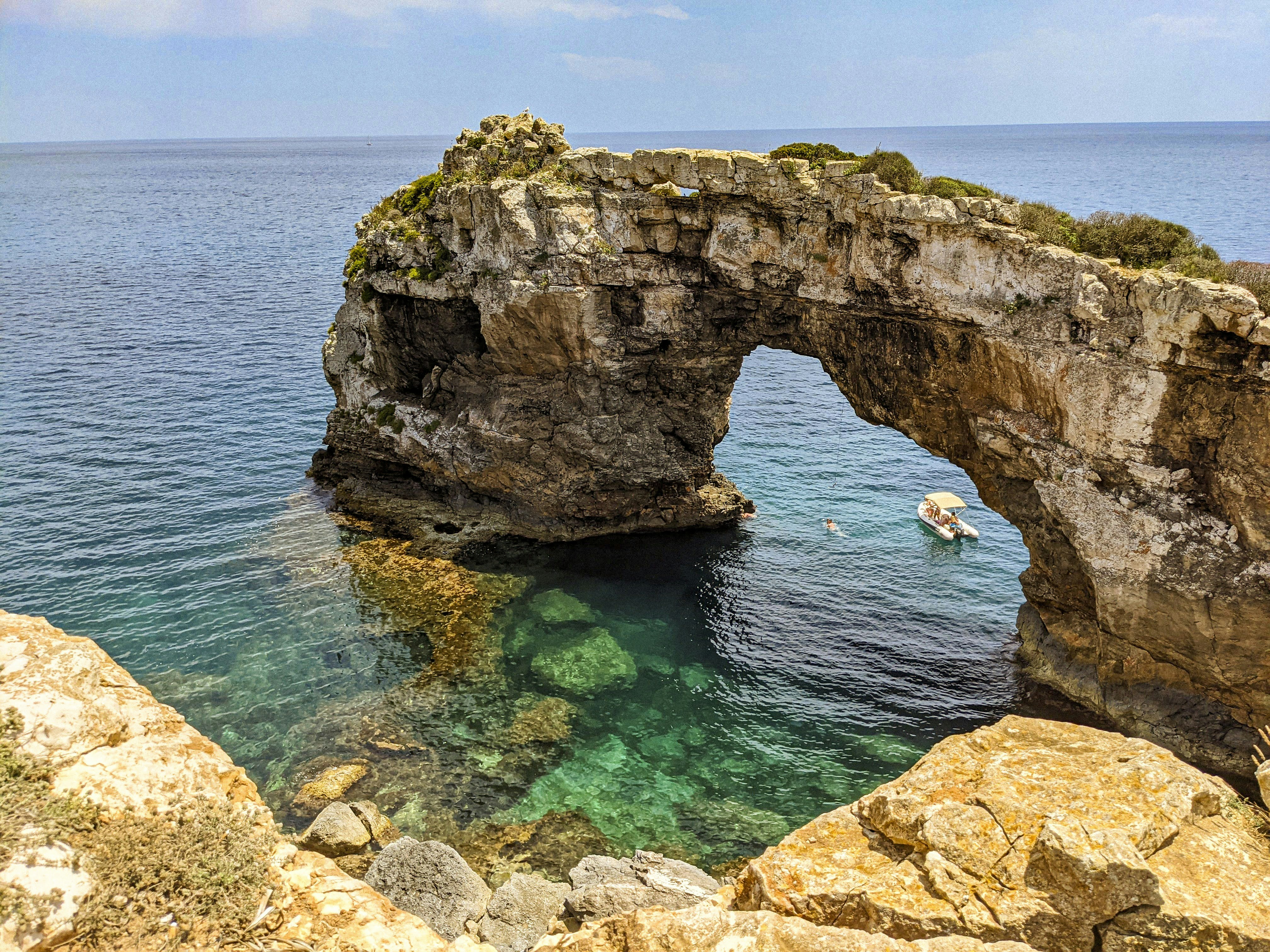 A large rock arch over a body of water photo – Free Ocean Image on Unsplash