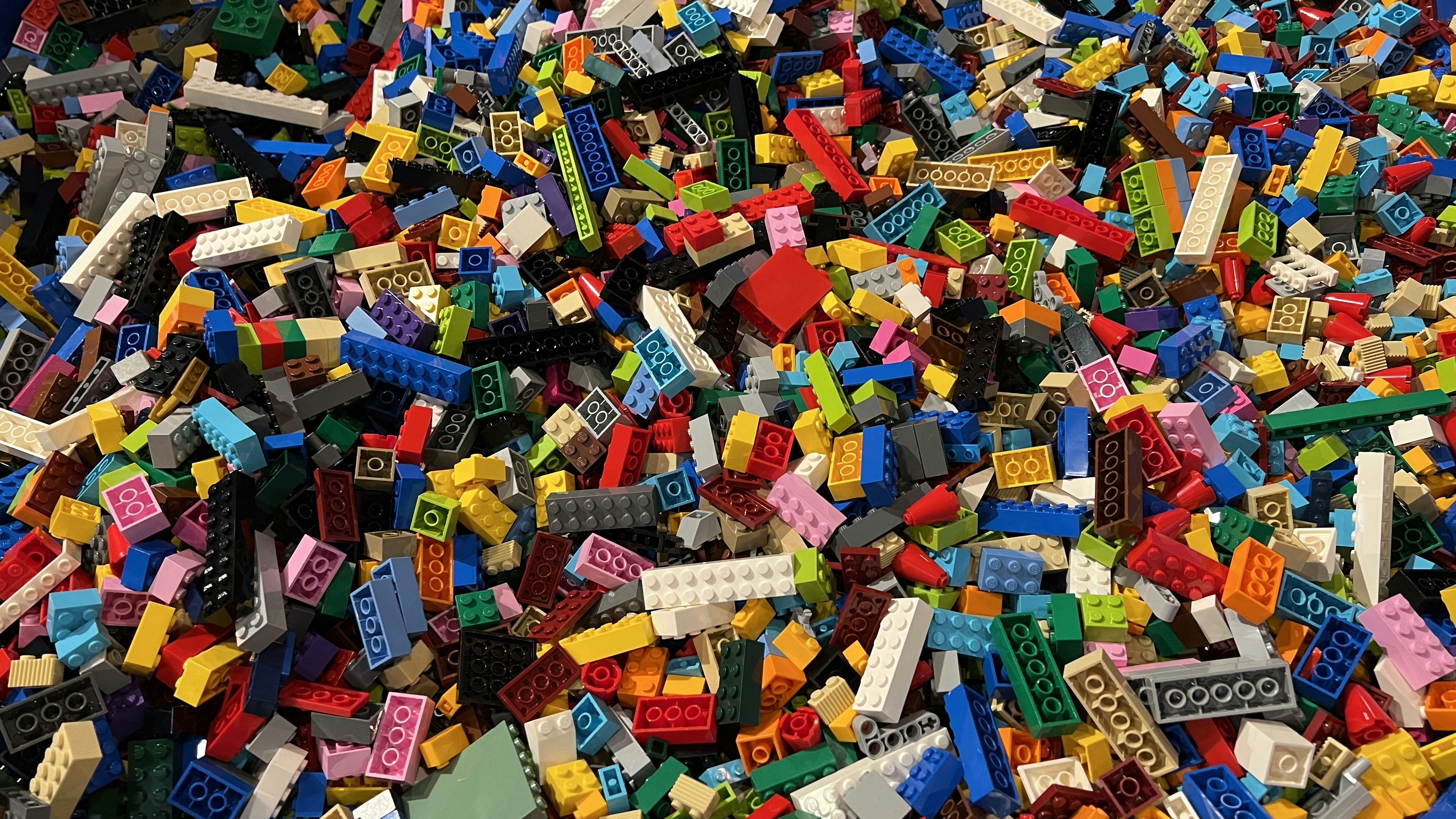 Vibrant assortment of LEGO bricks scattered across a surface, showcasing a variety of colors and shapes. Ideal for creative building inspiration.