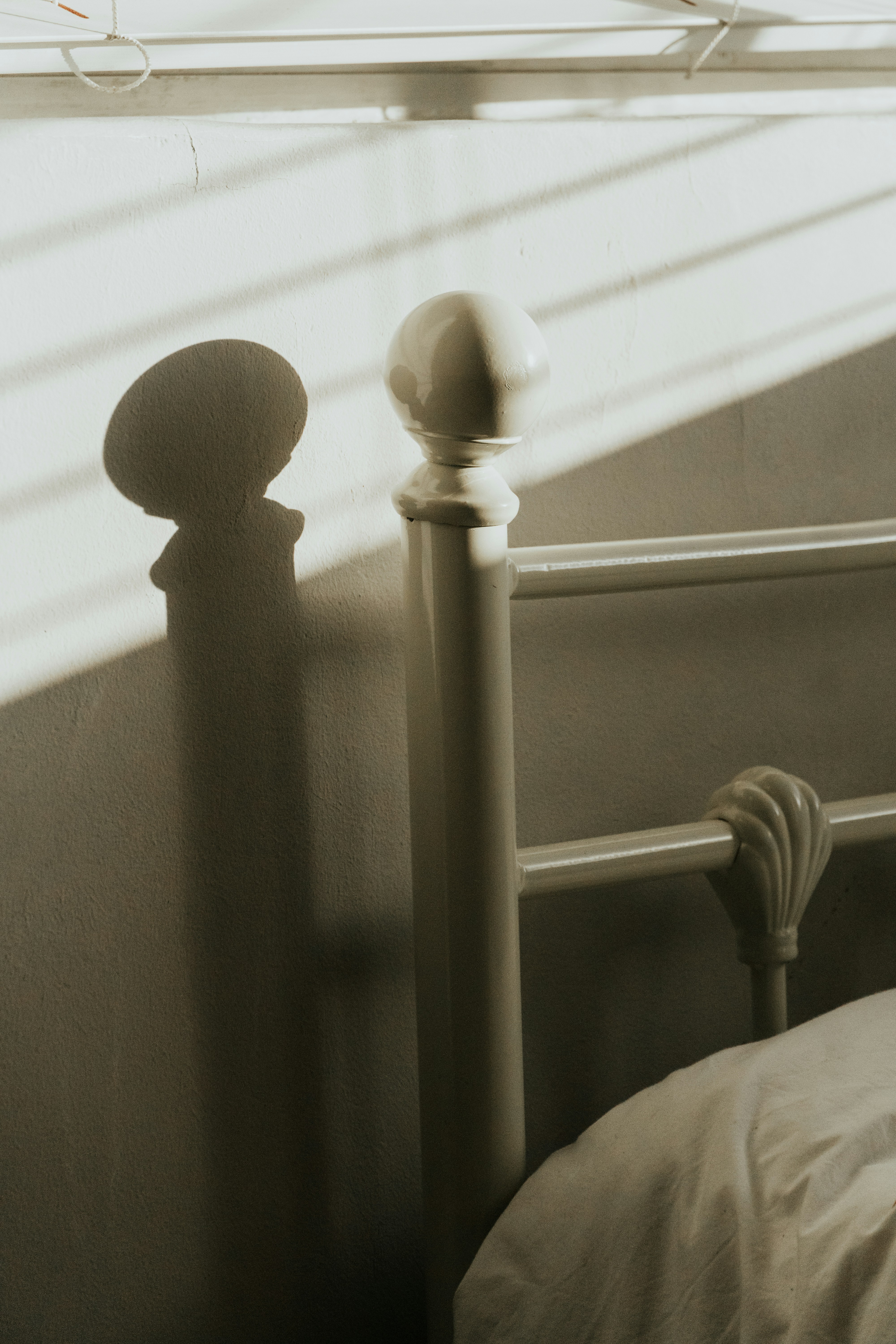 Sepia Stillness: A Bedpost Silhouette in Afternoon Light